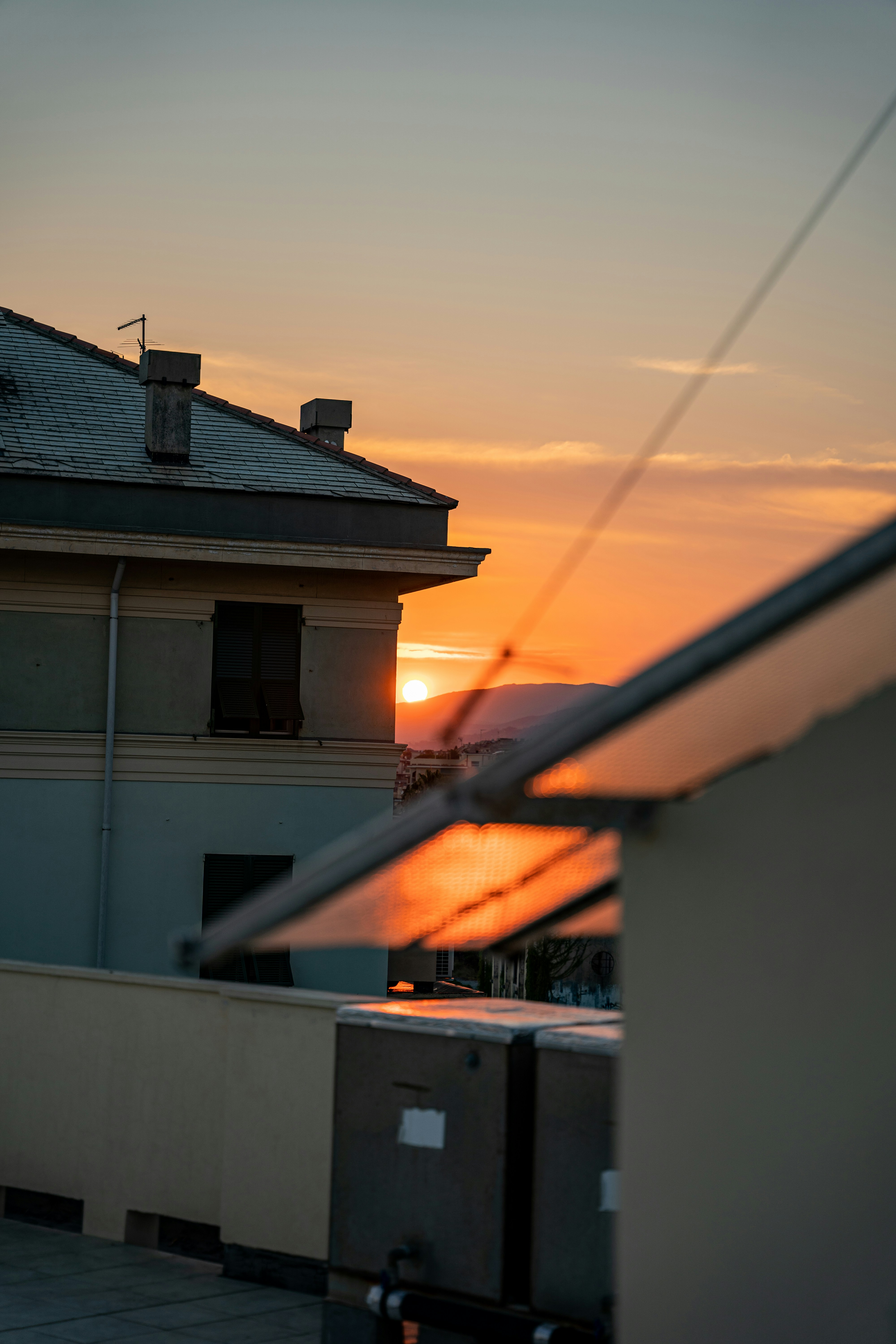 Sunset Between Rooftop Edges: Glass, Shadow, and Warm Light