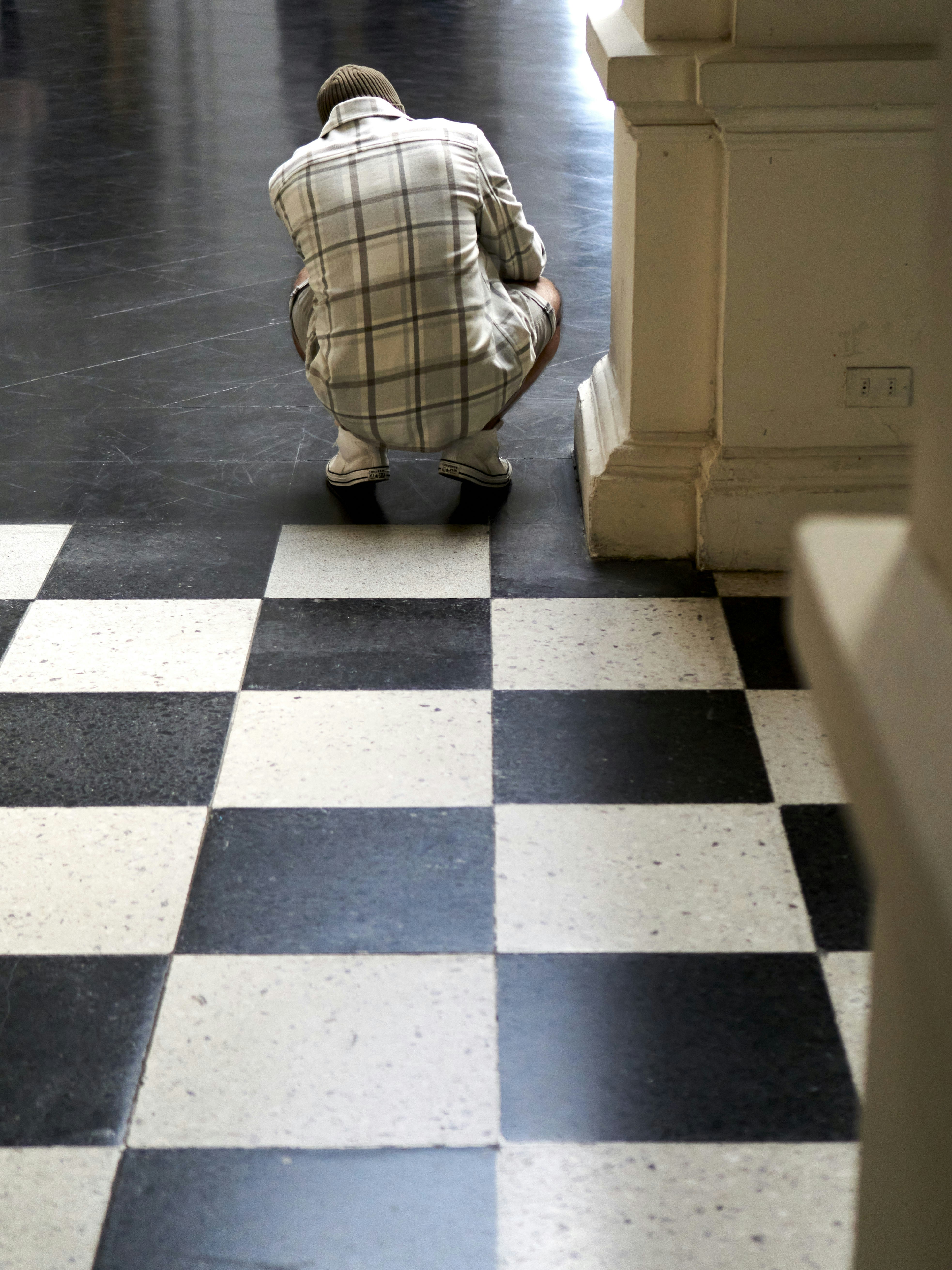 a person kneeling on a checkered floor