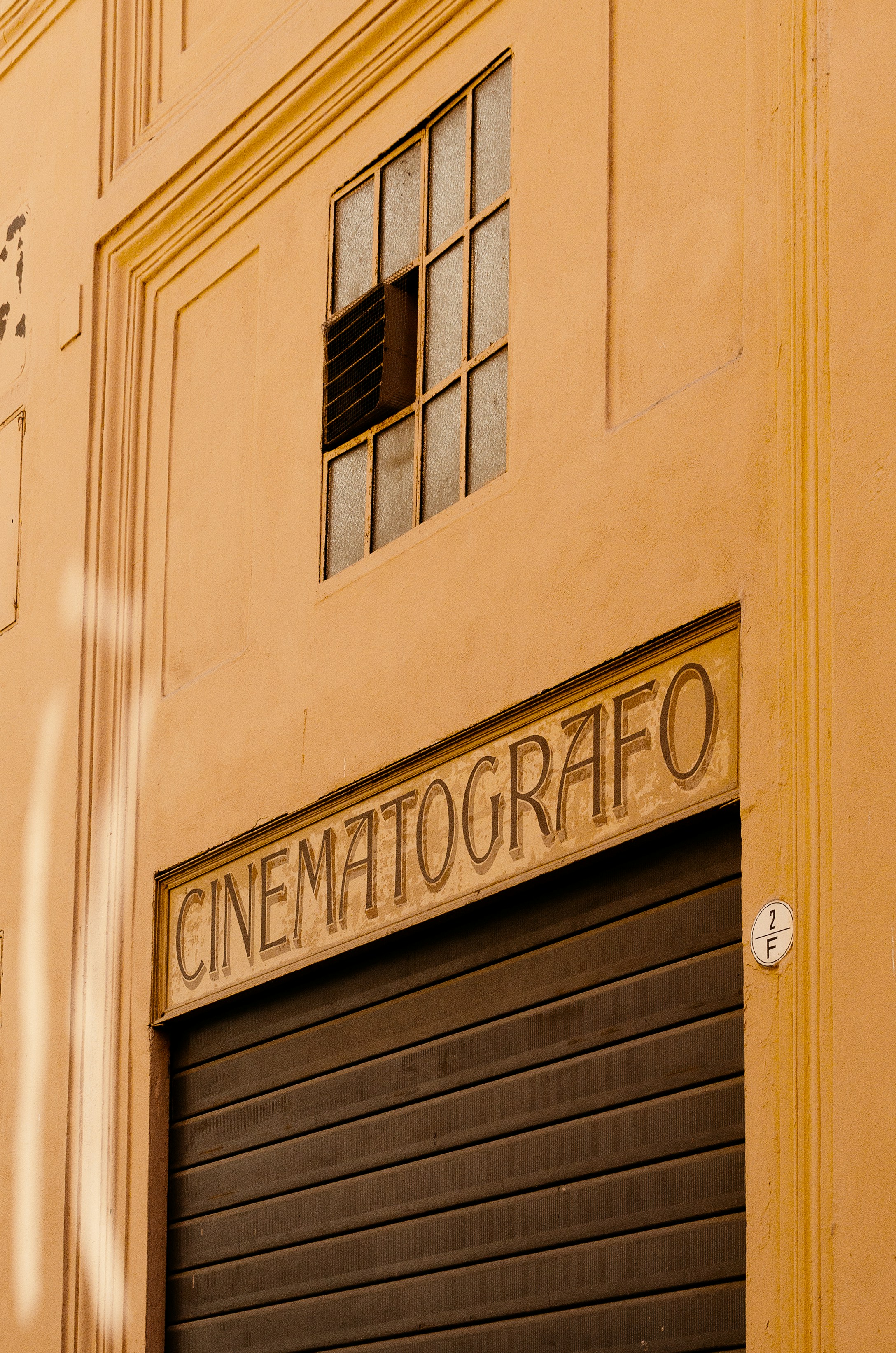 Sunlit Cinematografo Facade: A Closed Entrance with Vintage Sign