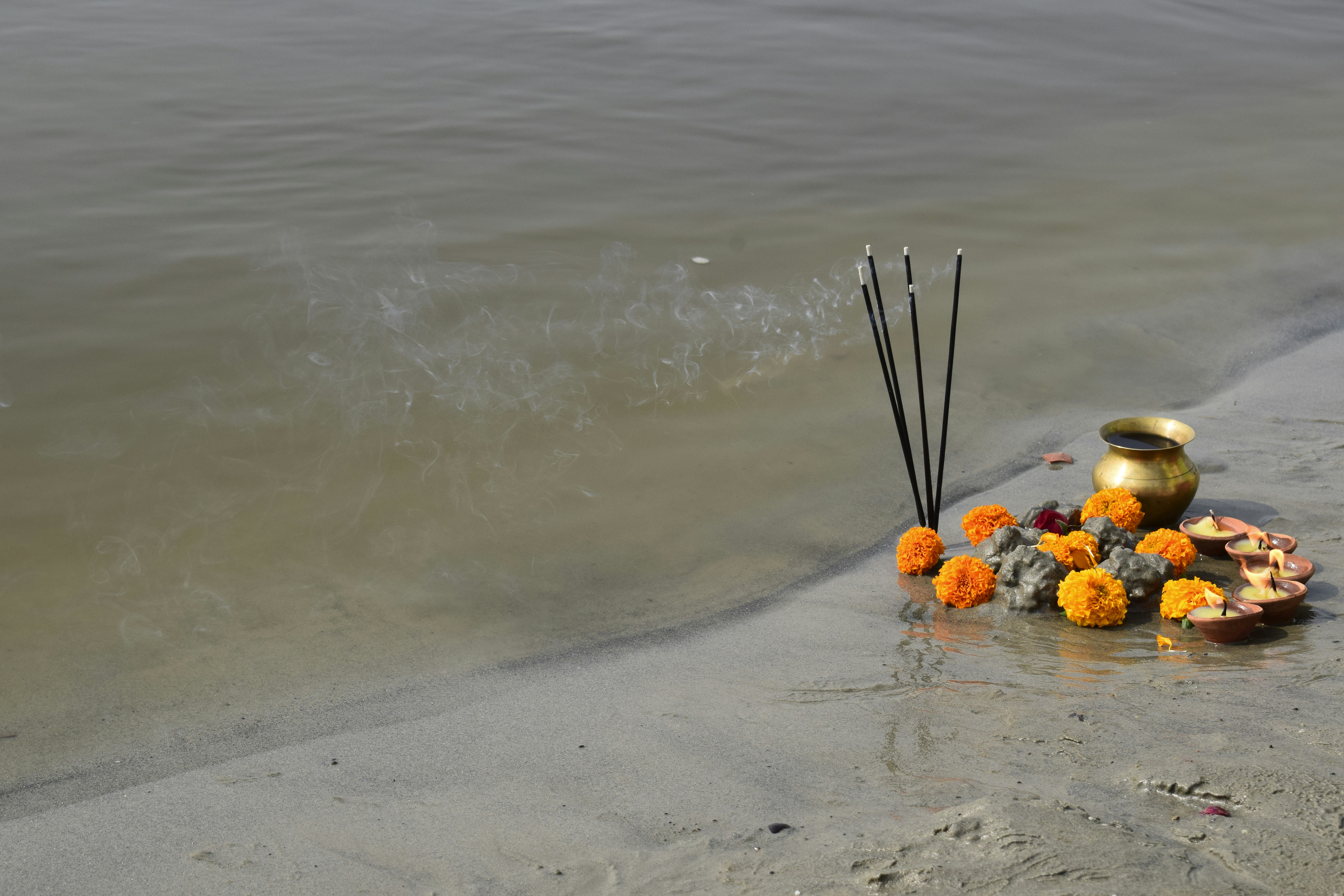 Tidal Edge Offerings: Incense, Marigolds, and Bronze Vessel by the Sea