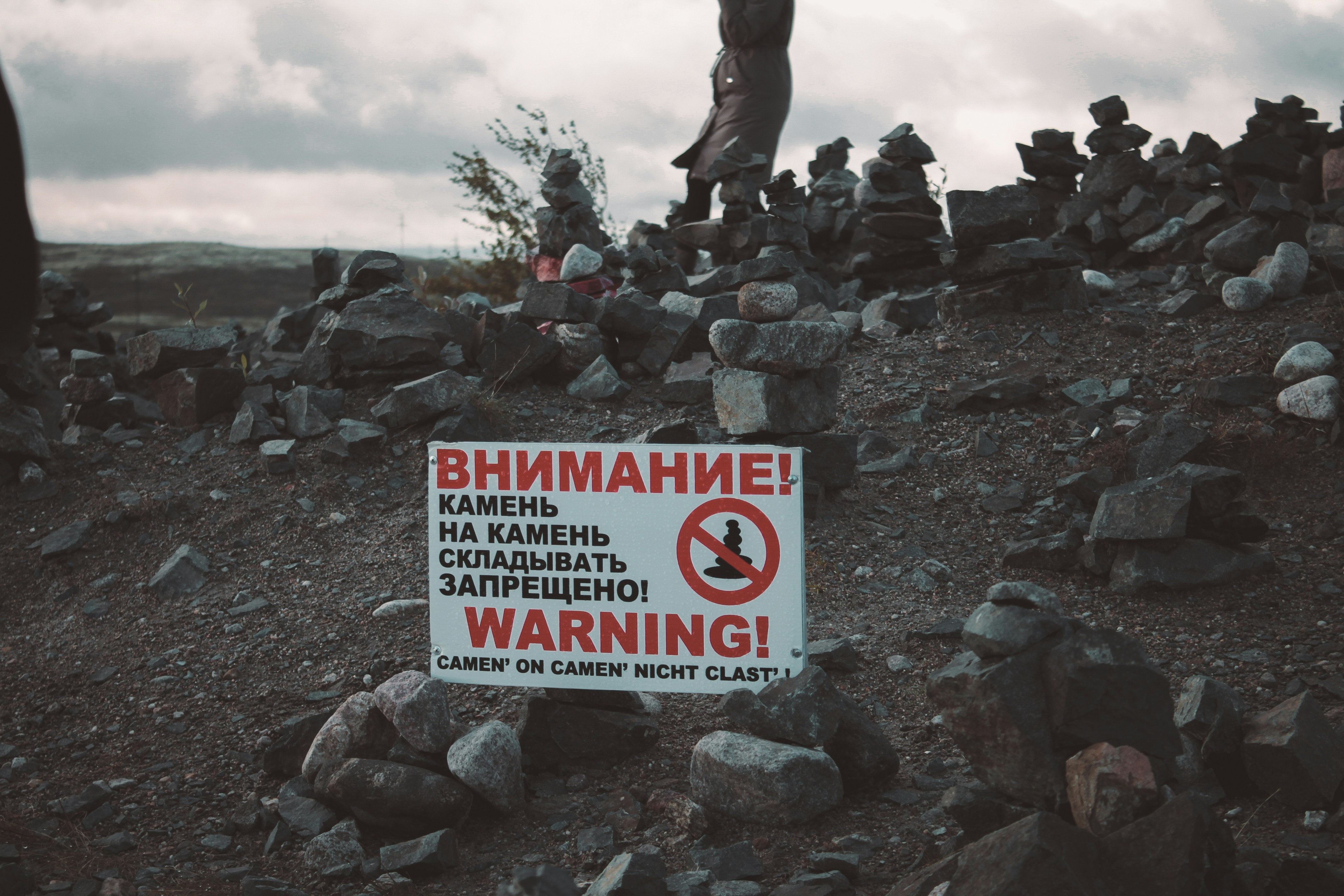 Boundary Markers and a Warning Sign in a Rugged Landscape
