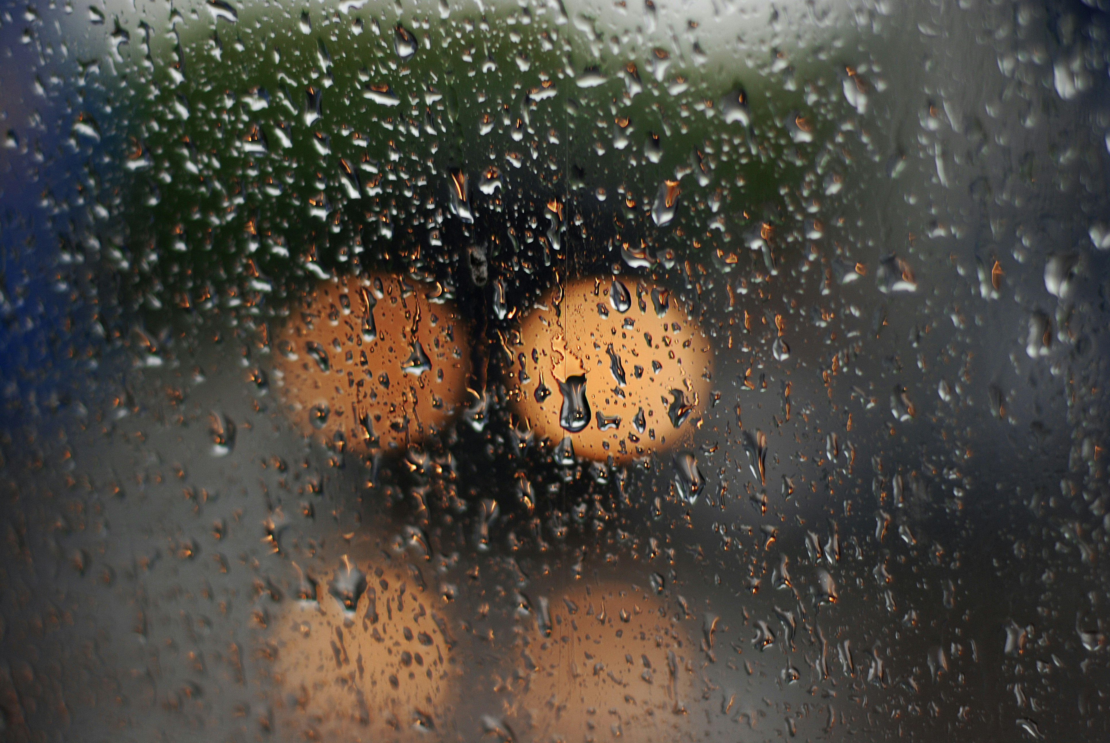 Warm Orbs Through Rain-Dotted Glass