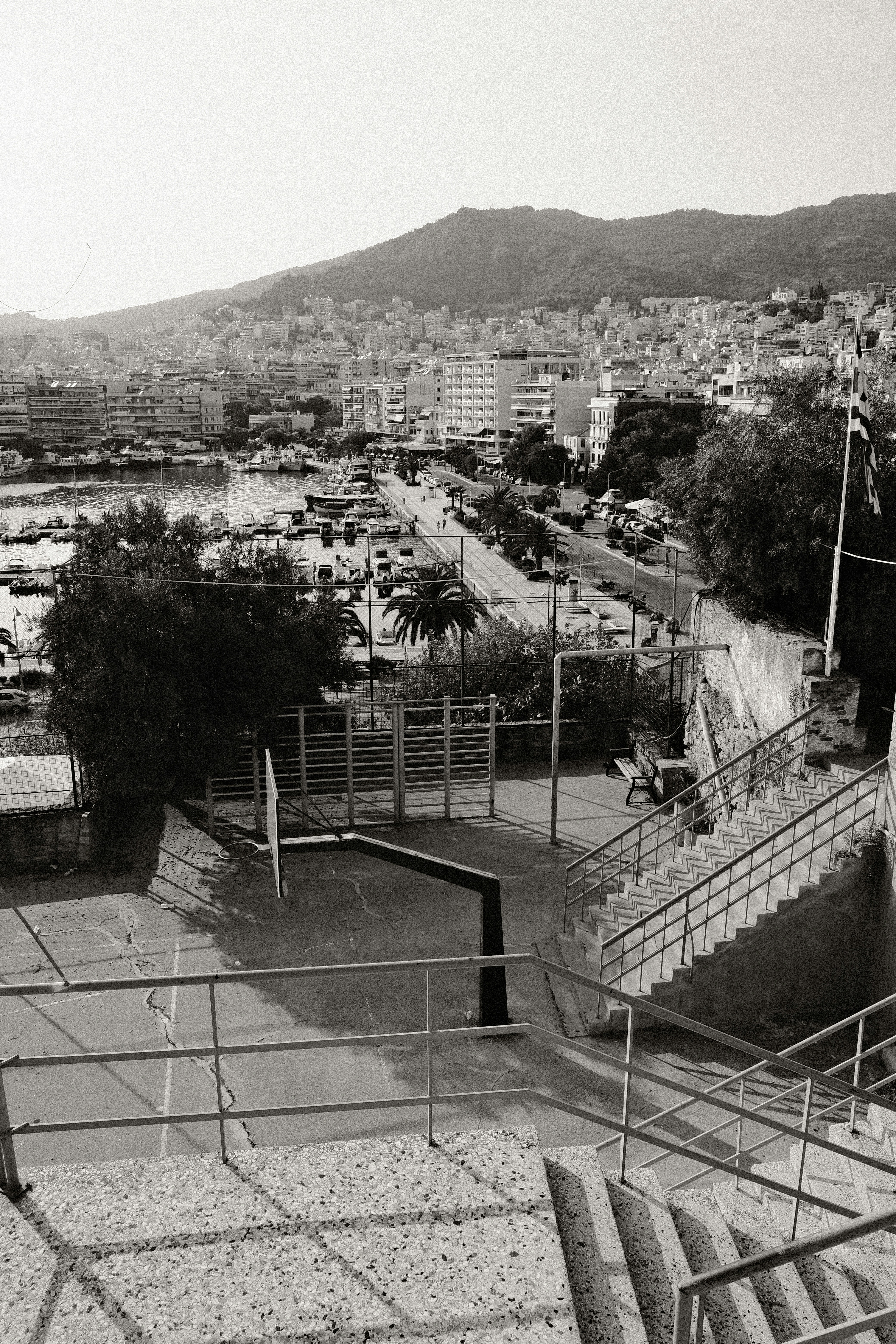 Kavala city in the background with basketball court in front, black and white 