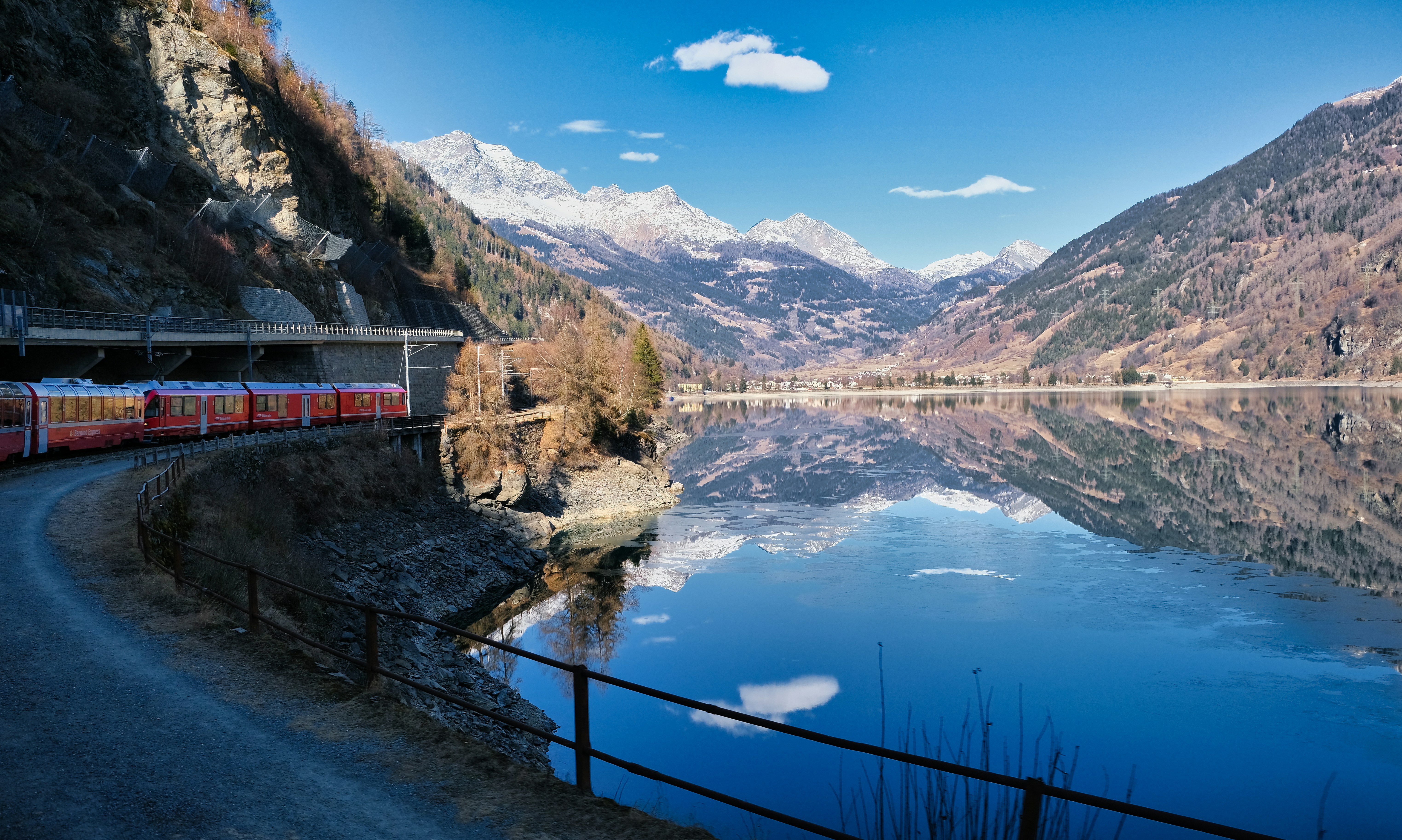 A train traveling on a bridge over a river photo – Free Berninapass ...