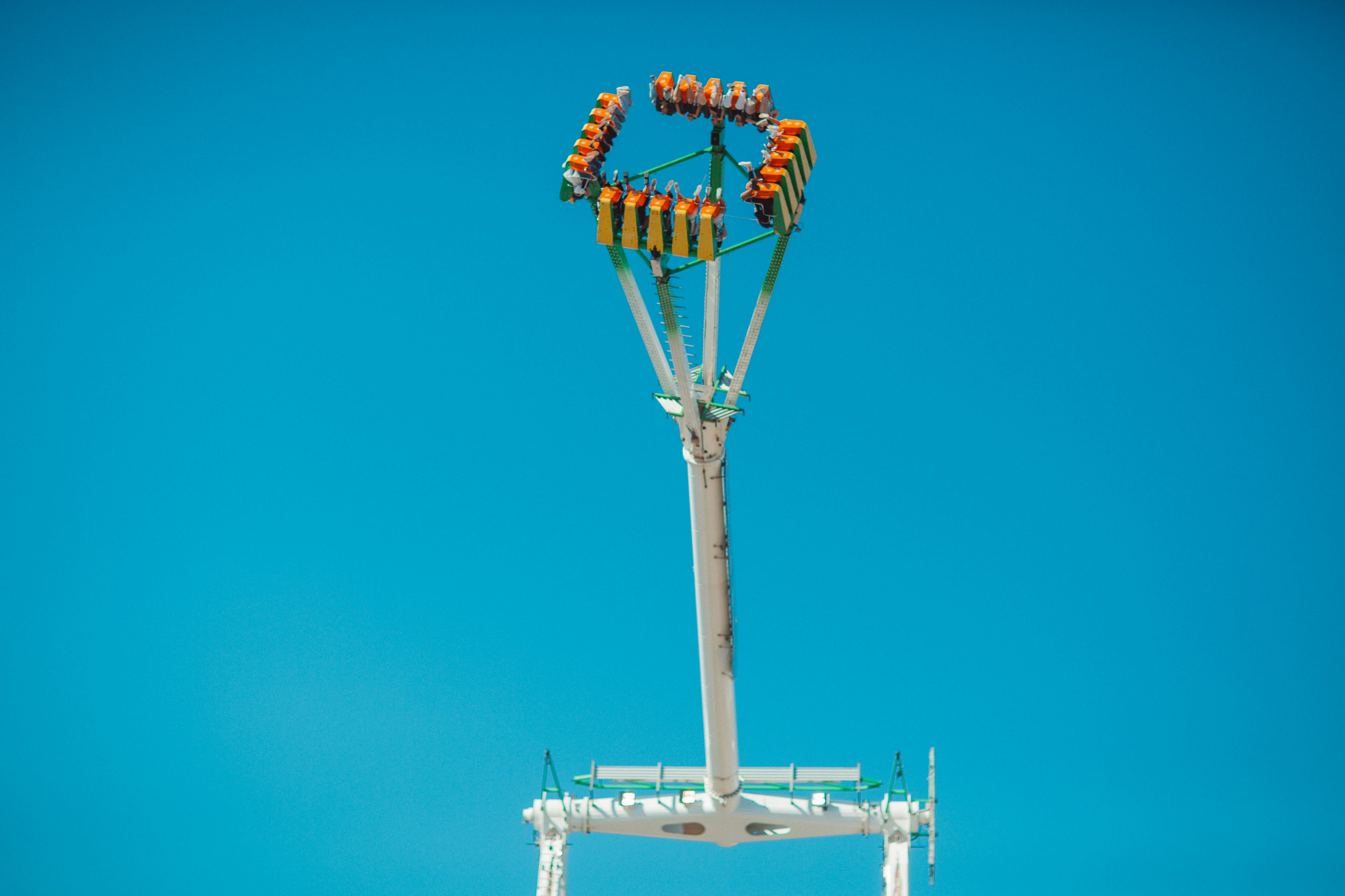 Amusement park ride elevating thrill-seekers against a clear blue sky.