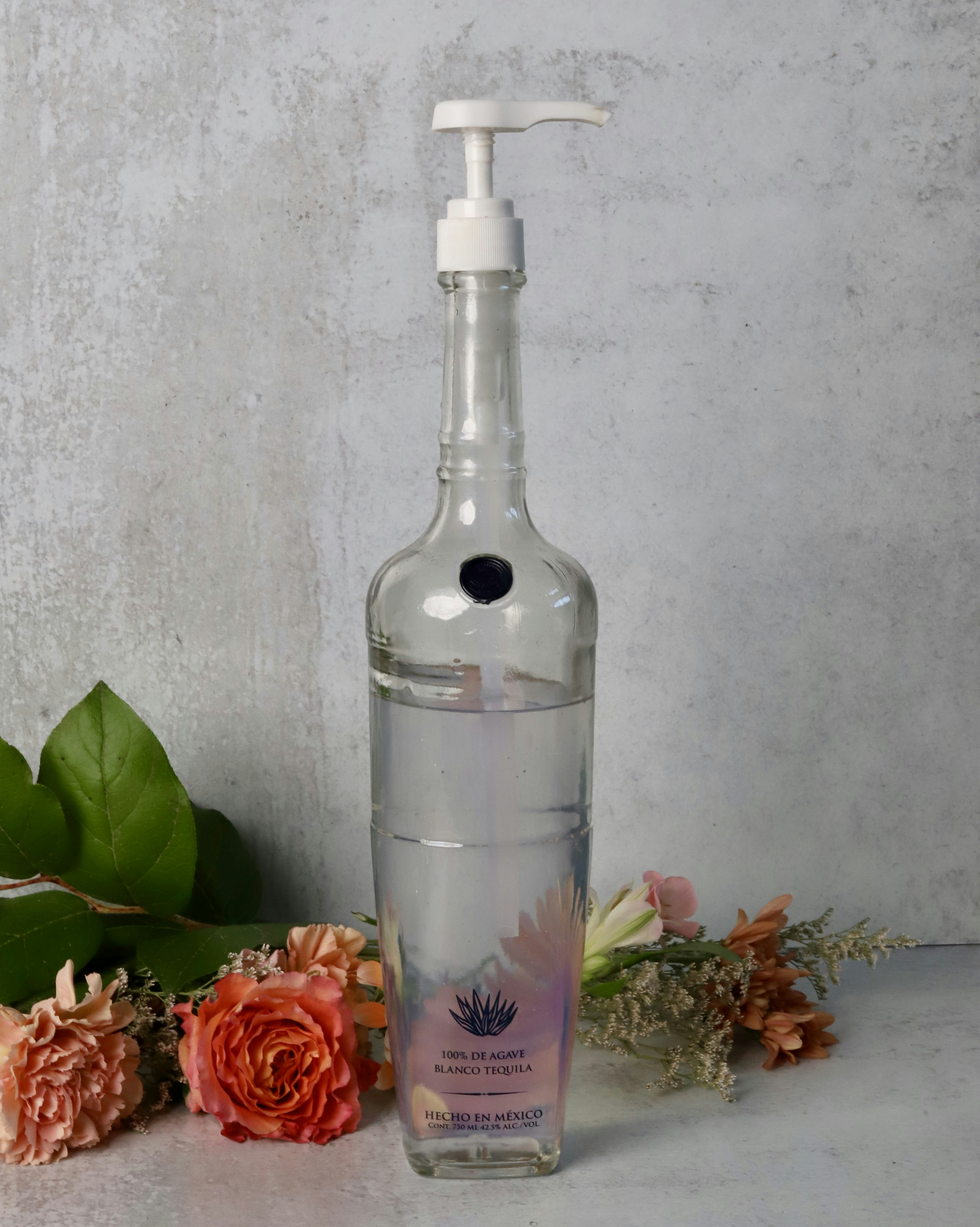 Pastel Still Life: A Centered Glass Pump Bottle Surrounded by Florals