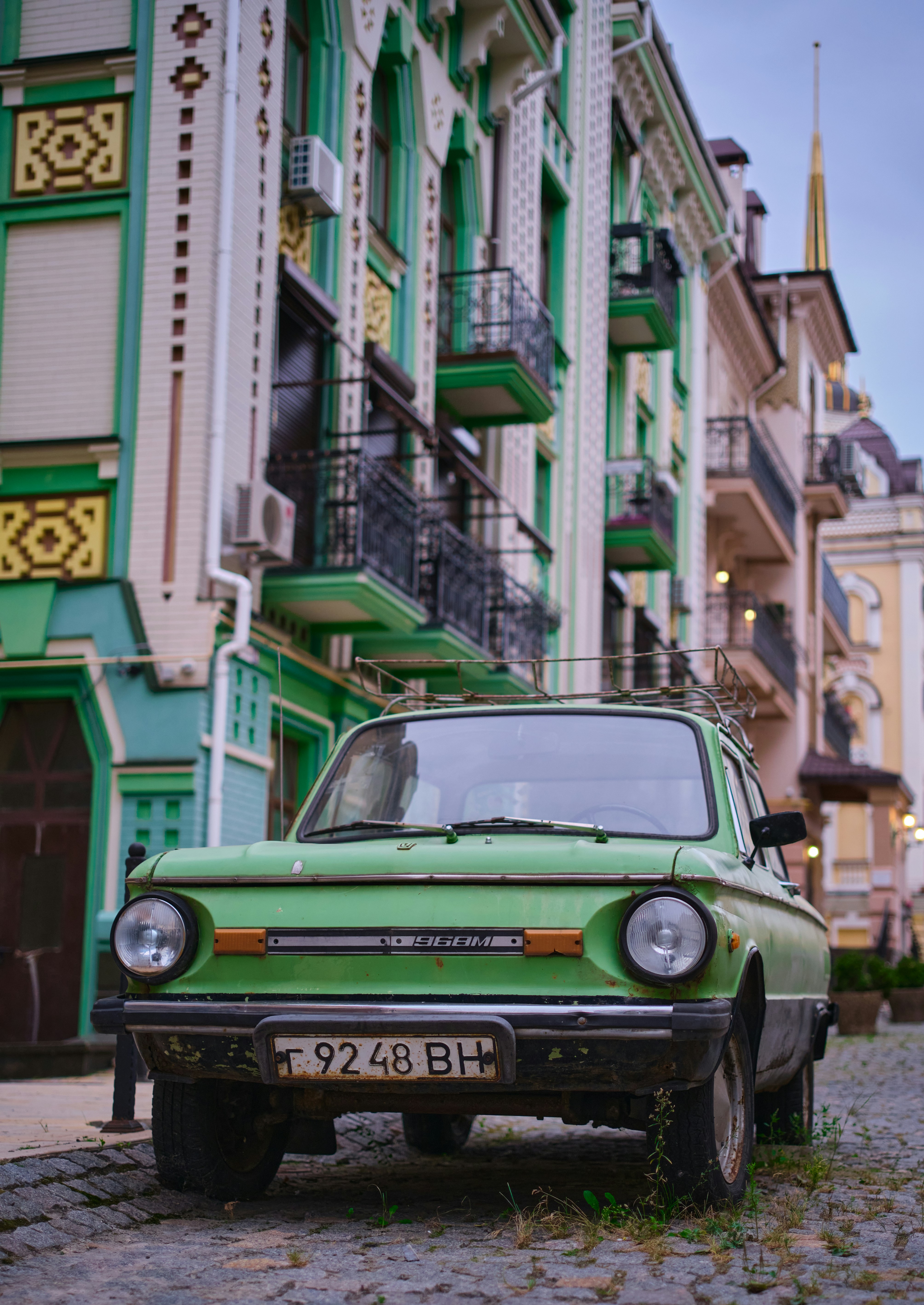 a green car parked in front of a building