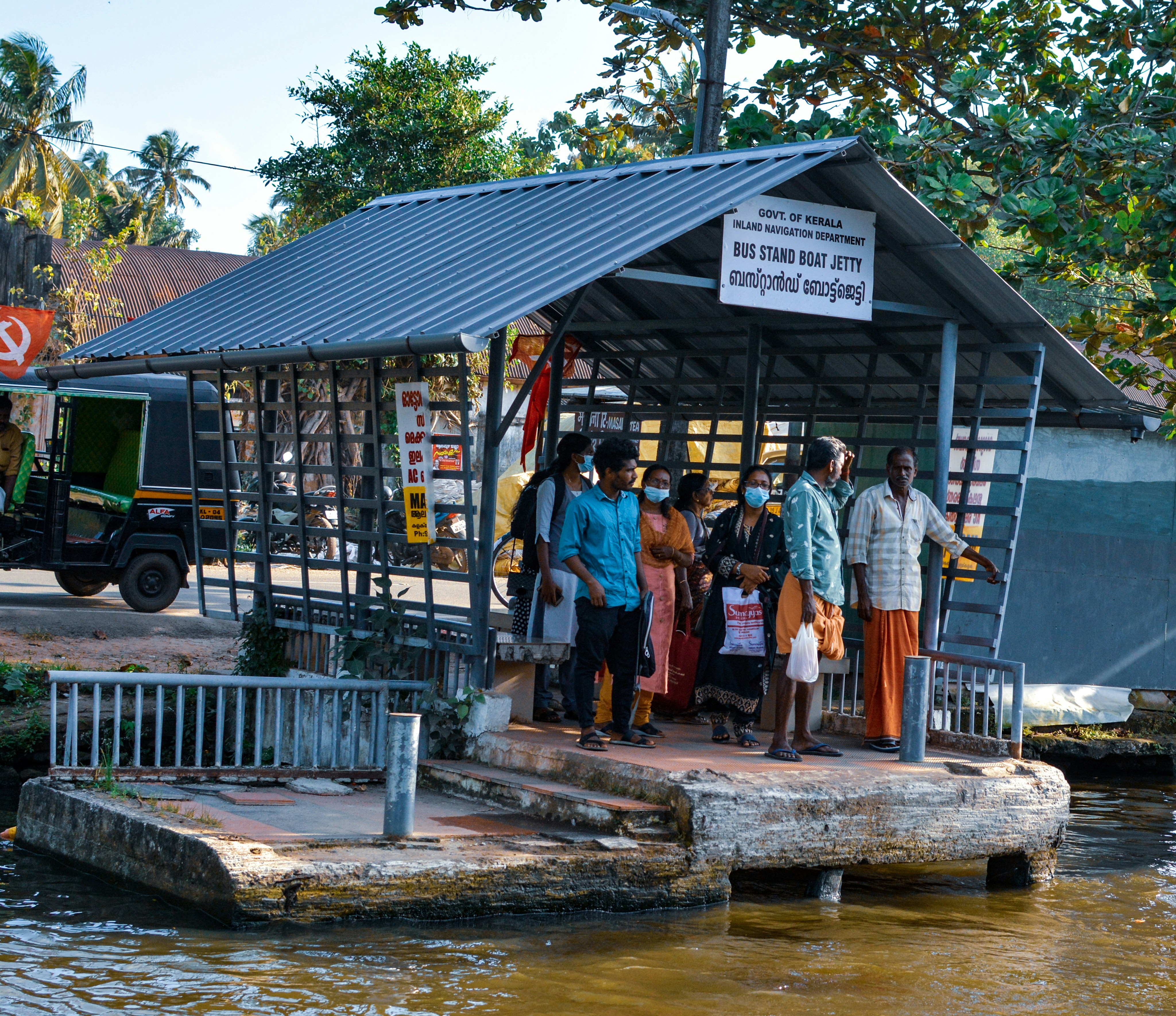 daily commuters | a group of people standing outside a small shop