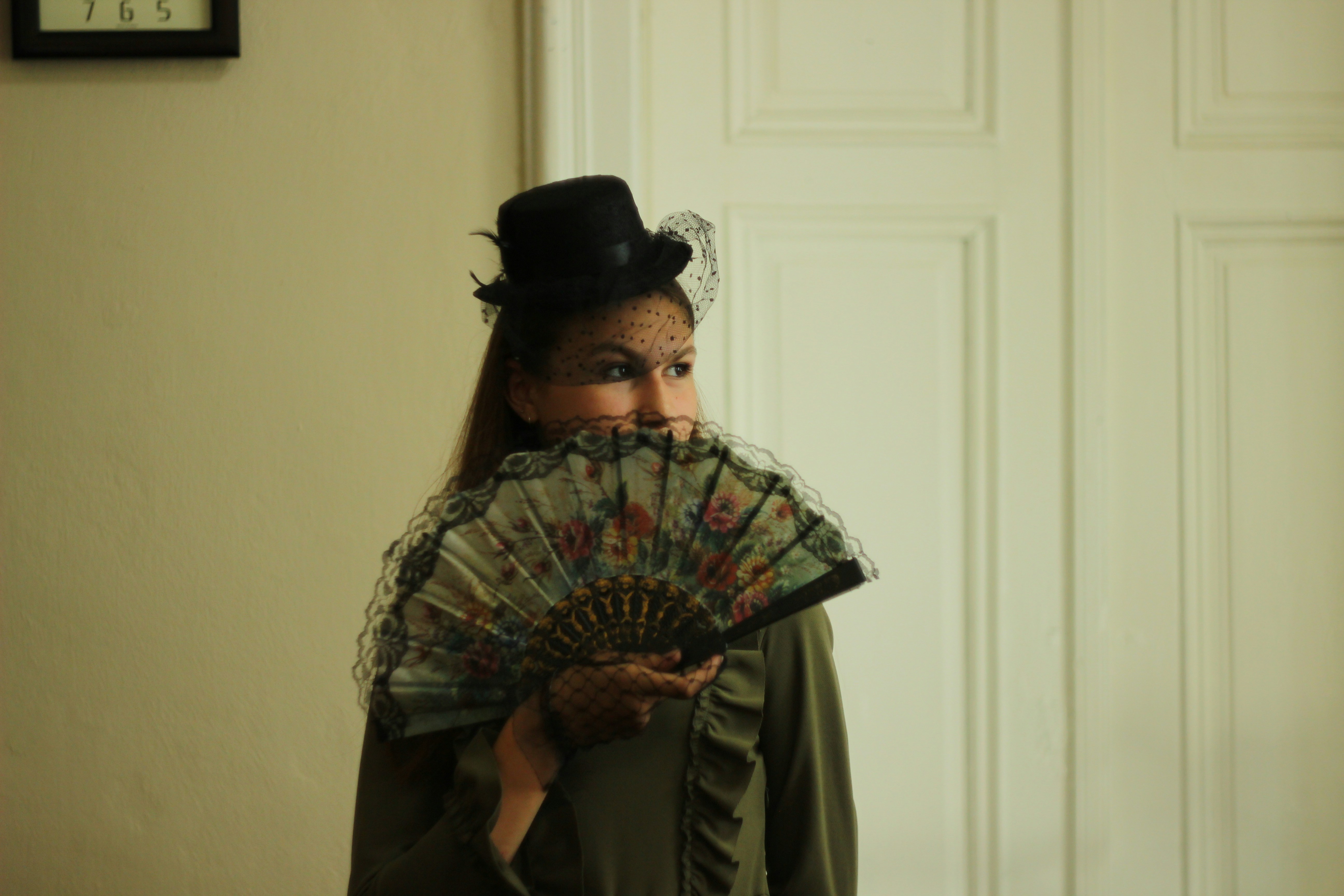 Elegant veil, vintage fan: a quiet moment by the closed doors