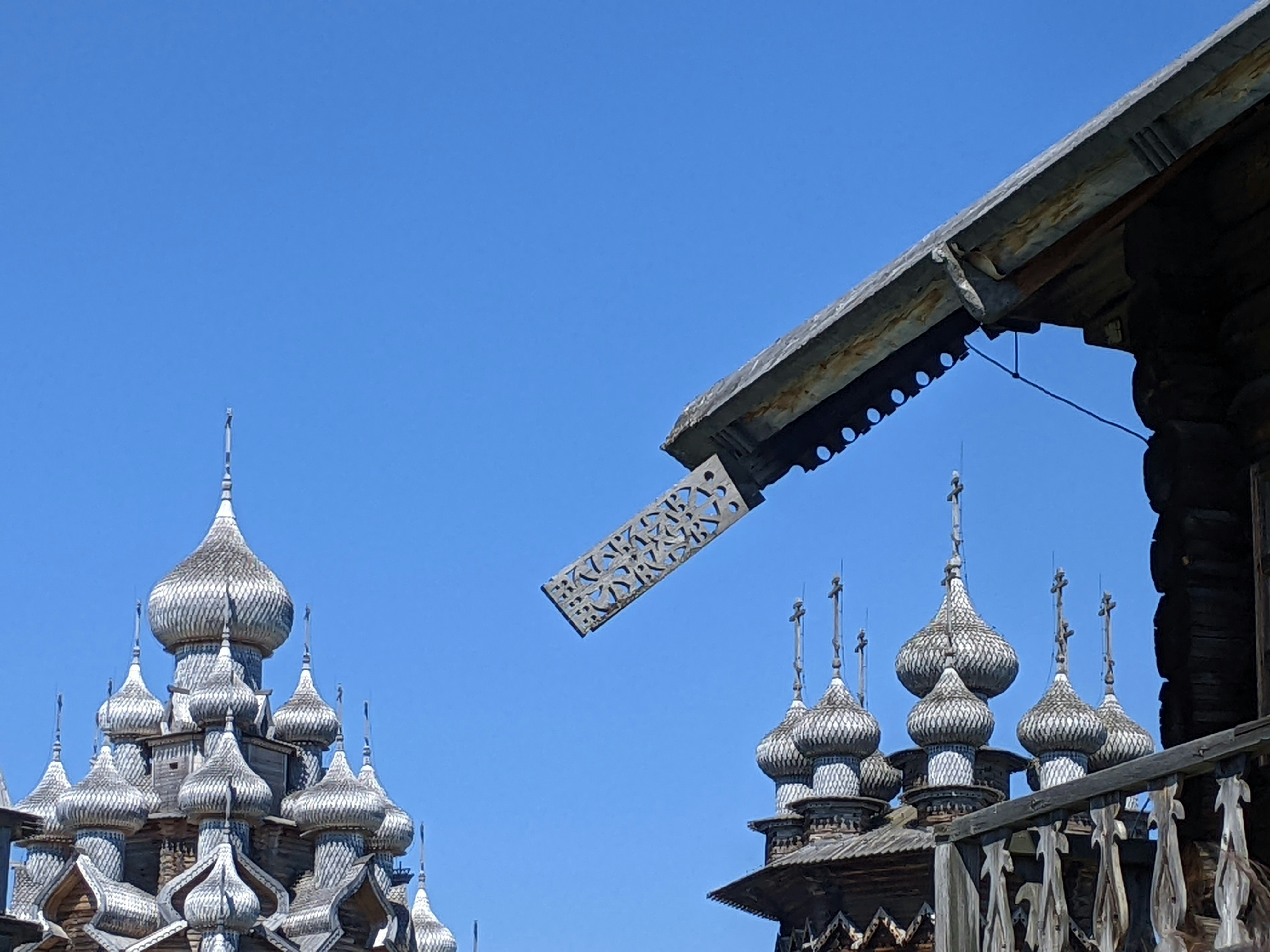 Silvery Onion Domes Framing a Timber Roof Against a Pristine Blue Sky
