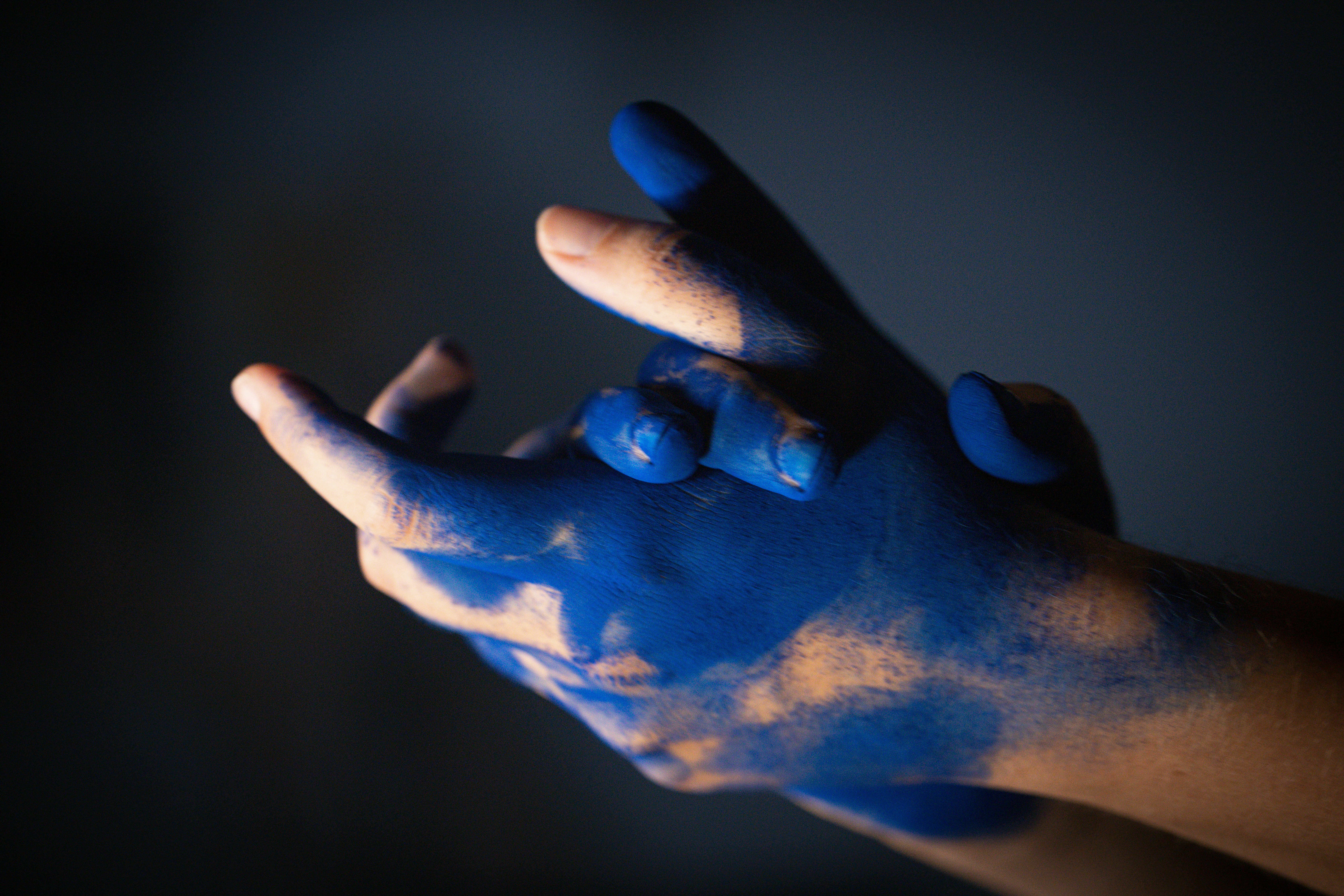 Cobalt Glow on Hands: A Quiet Gesture in Darkness