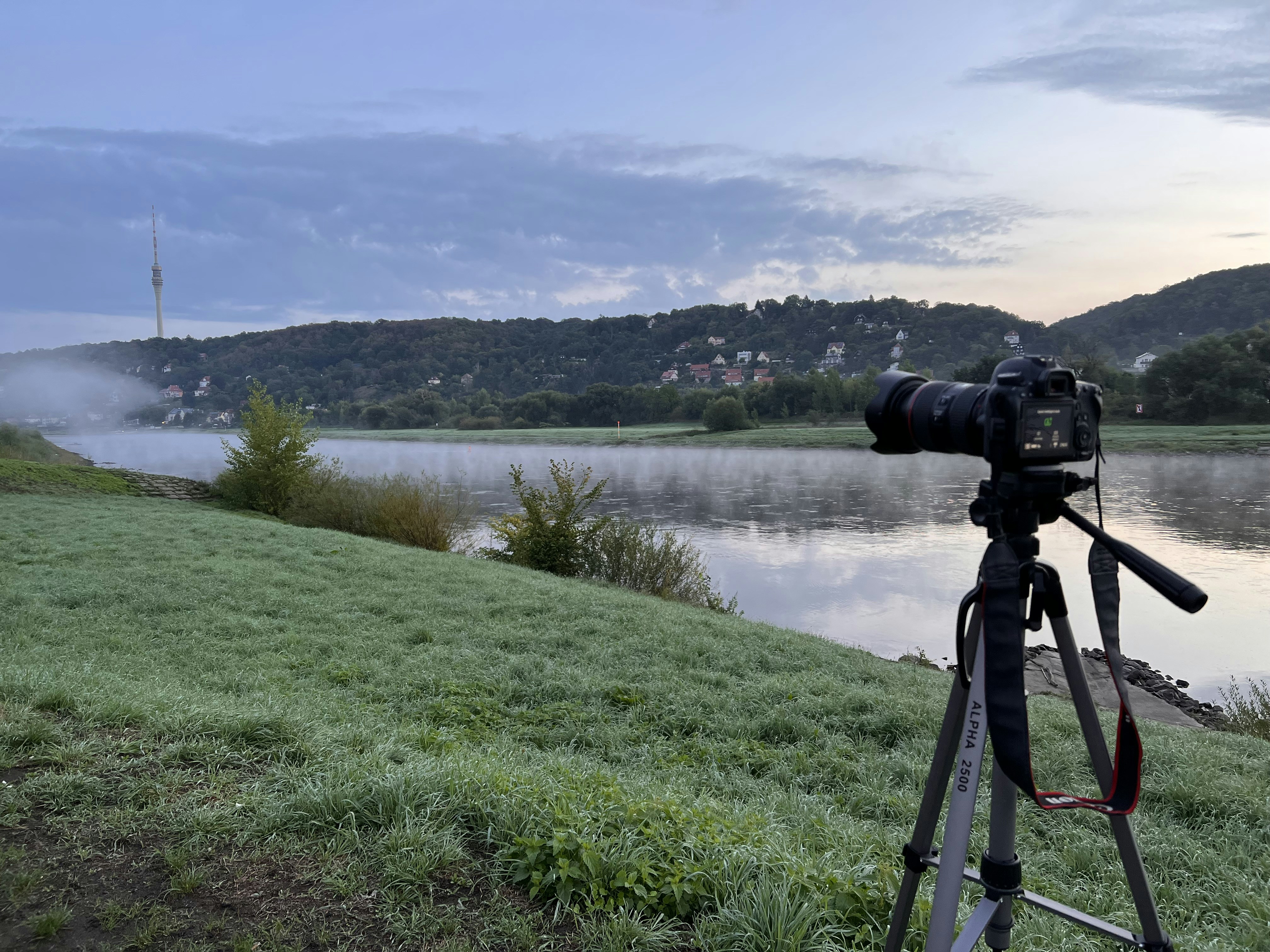 a camera on a tripod in front of a lake