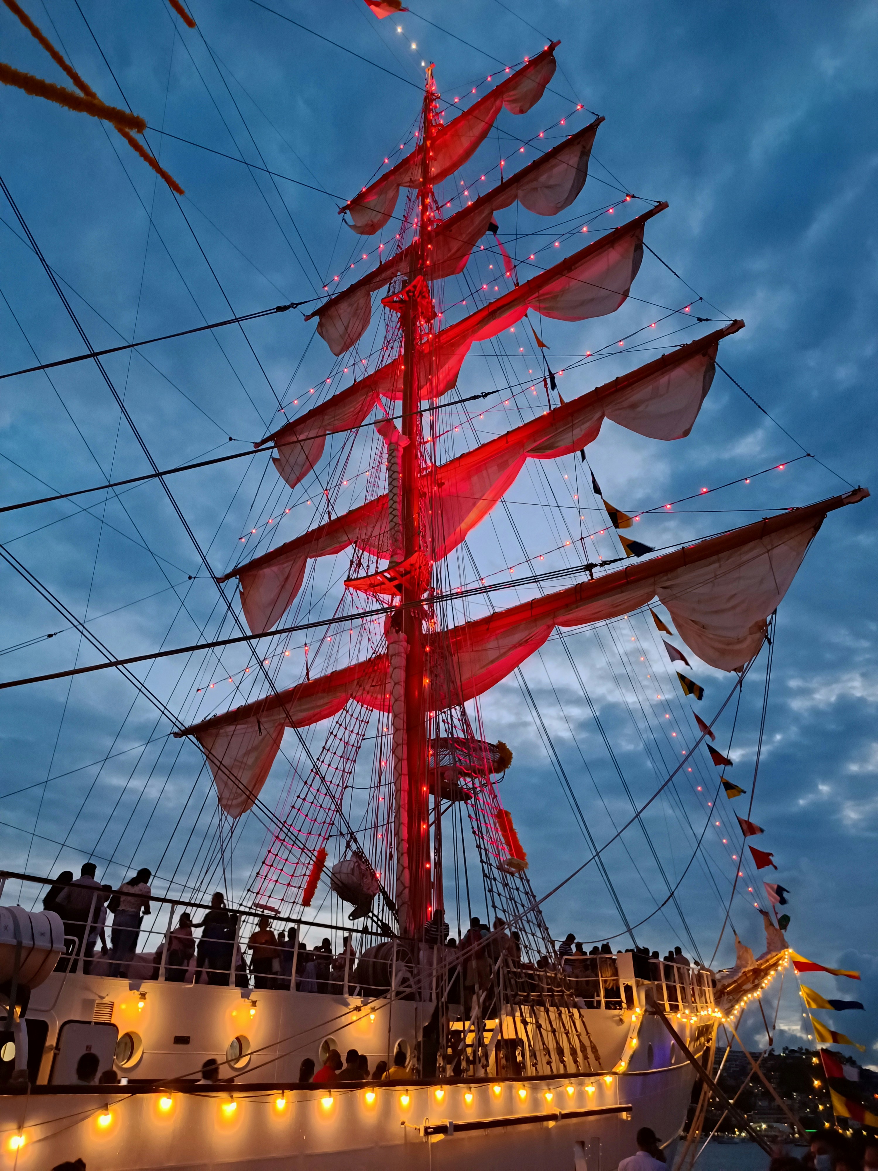 Crimson Rigging at Dusk: A Sail under Neon Night Lights