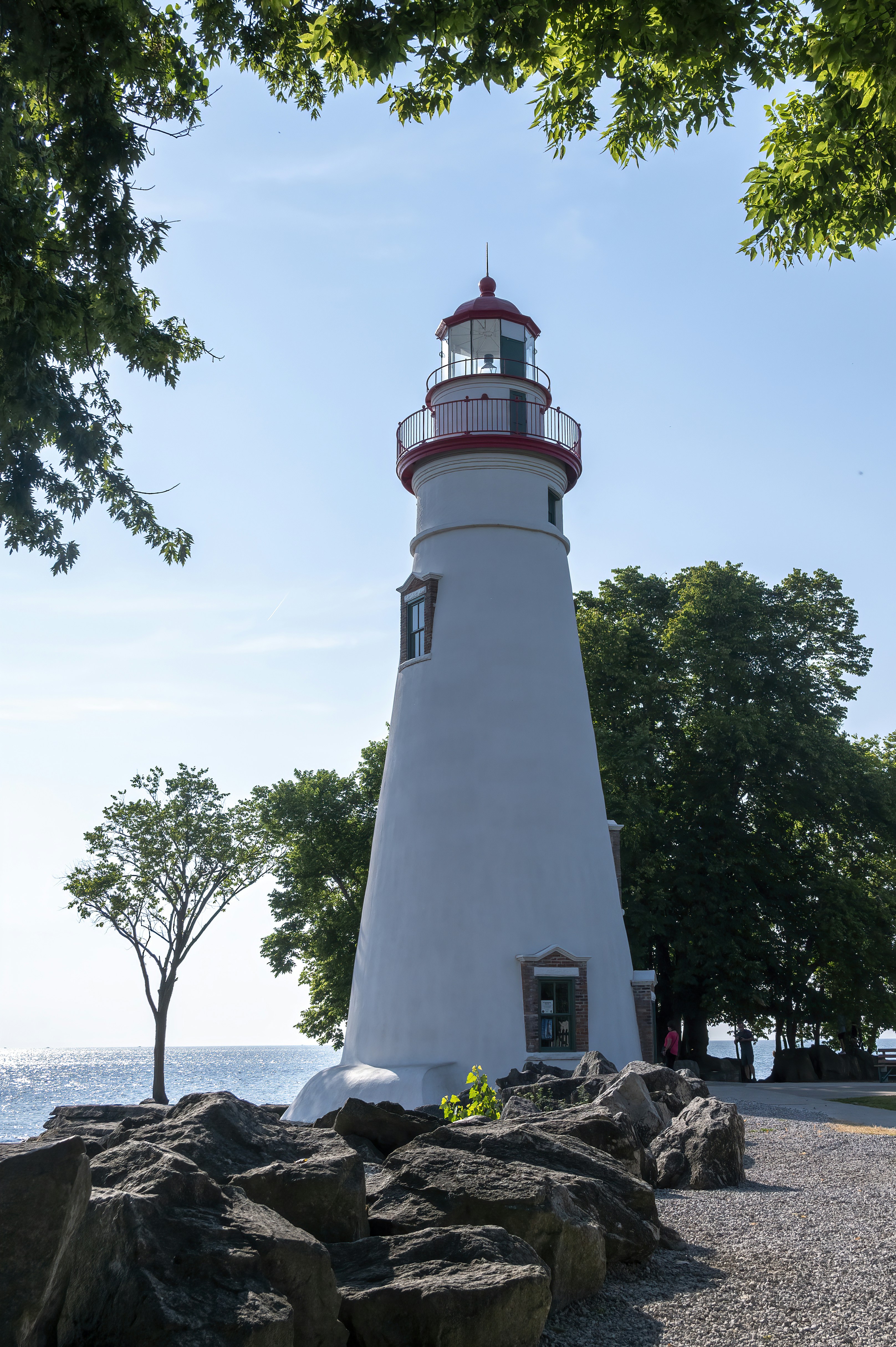 A white lighthouse on a rocky beach with marblehead light in the ...