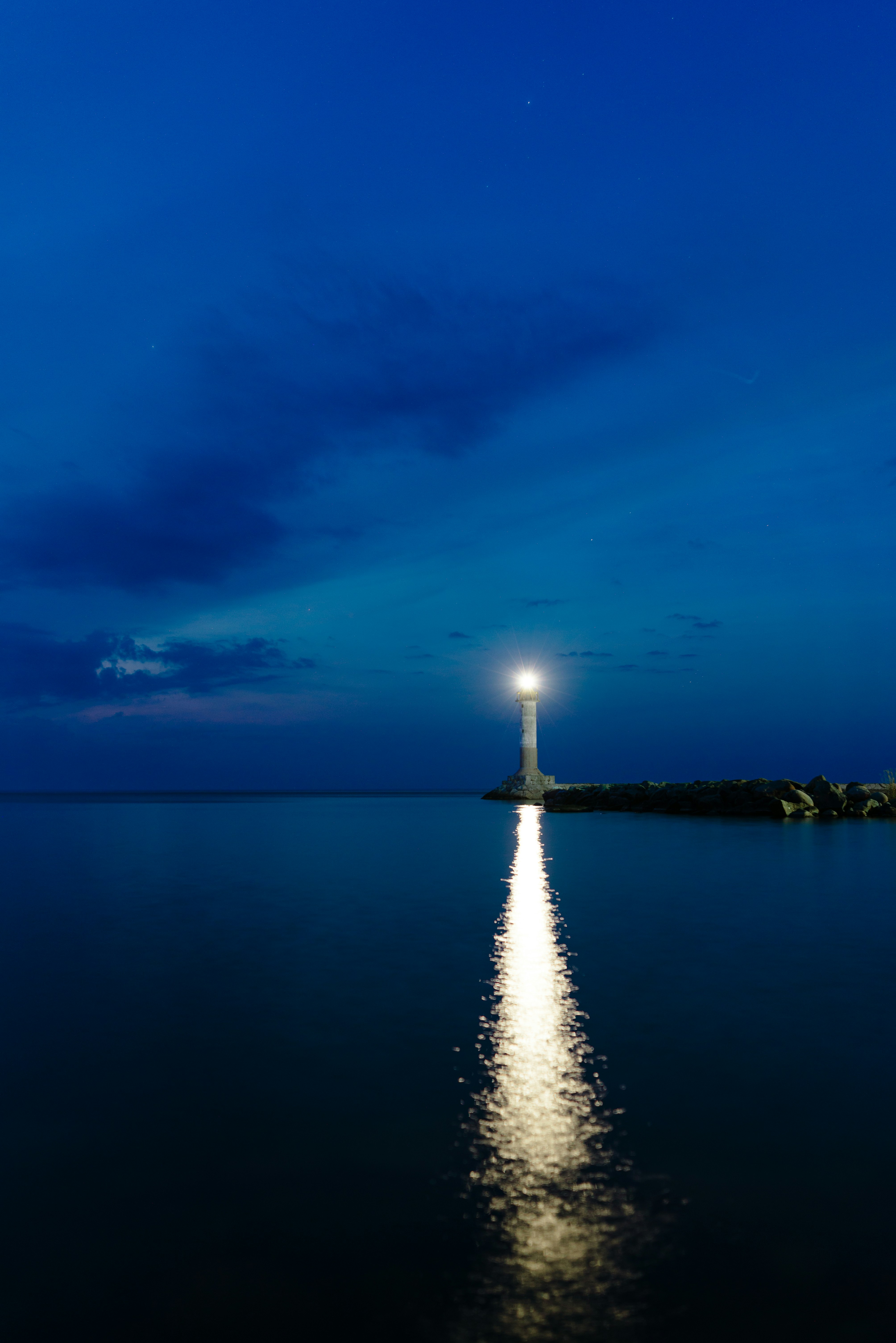 Lighthouse Halo: A Night Passage Across Calm Waters