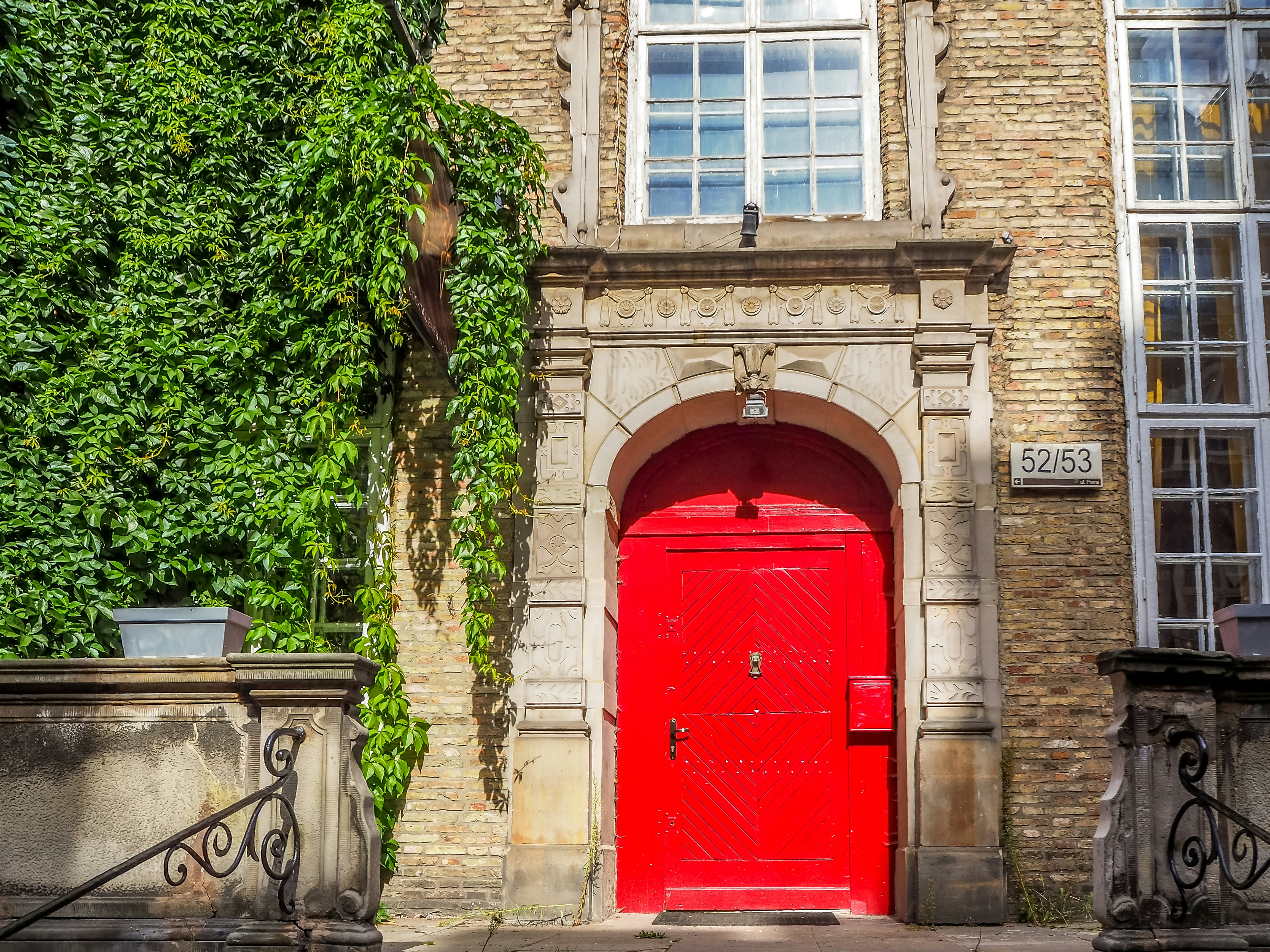 Une porte rouge sur un bâtiment photo – Photo Pologne Gratuite sur Unsplash