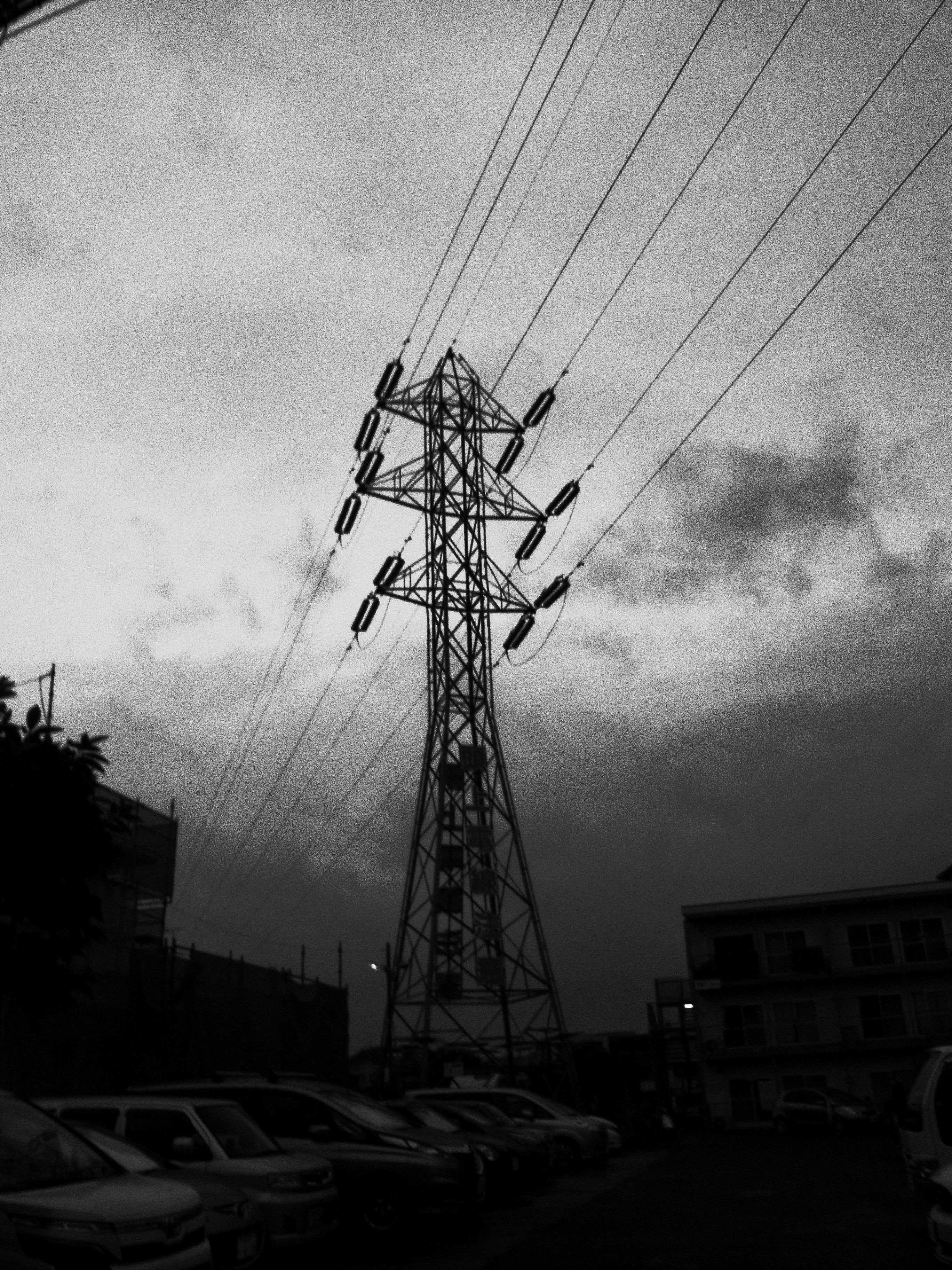 Monochrome Lattice: The Quiet Power Tower Reaches the Cloudy Sky