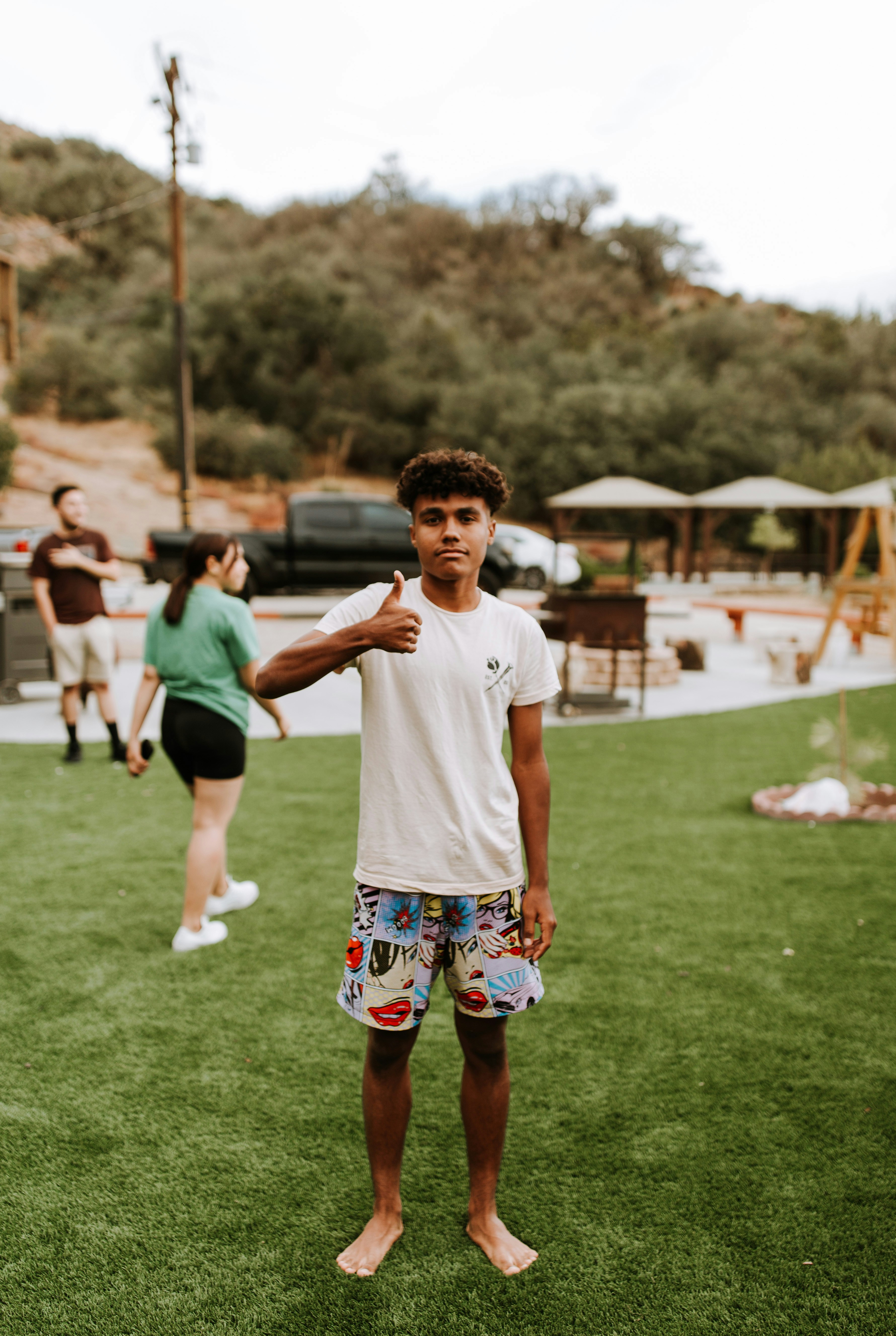 Thumbs Up on the Field: Central Figure under Outdoor Canopy
