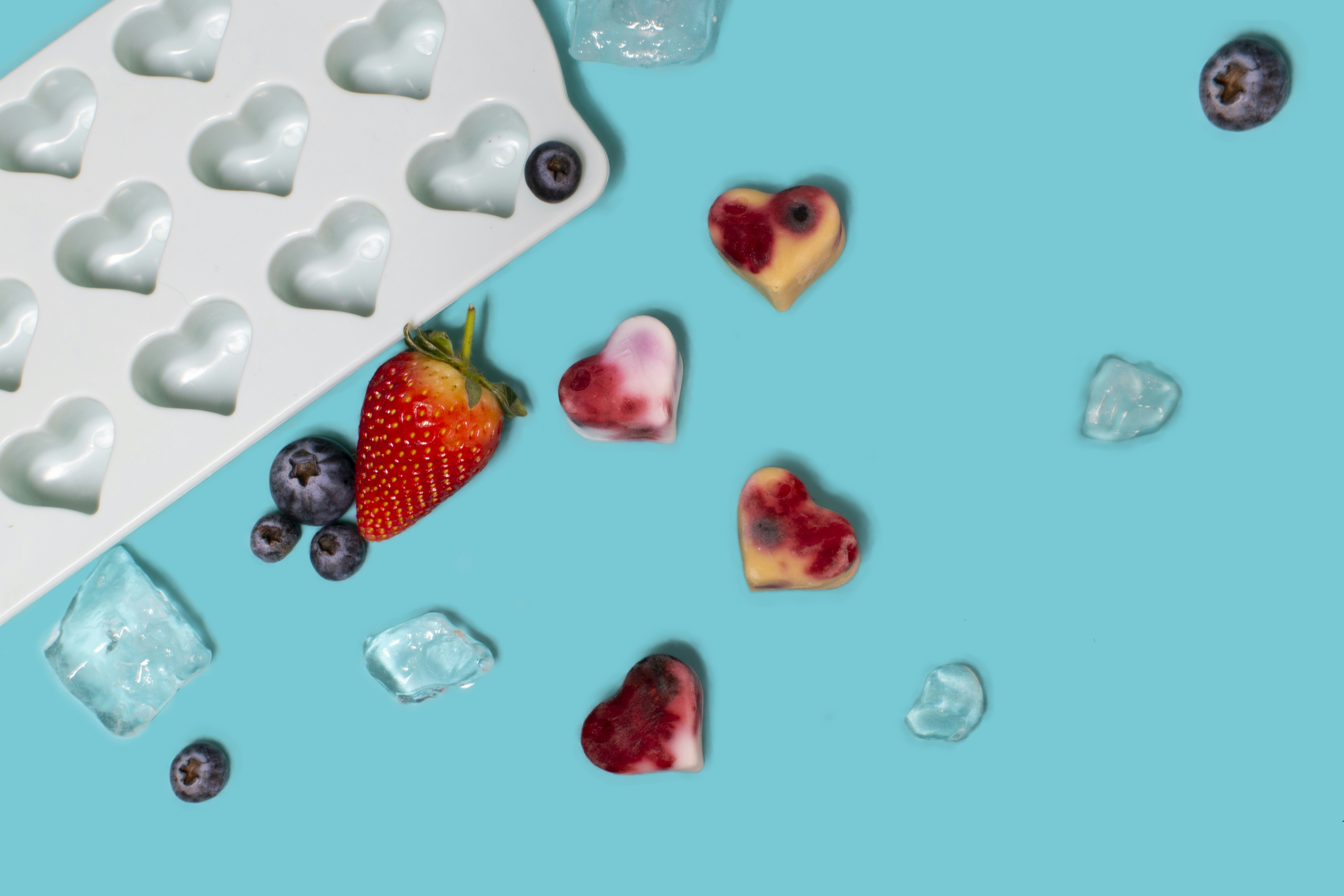 Strawberries and Hearts Spill Across a Bright Cyan Backdrop