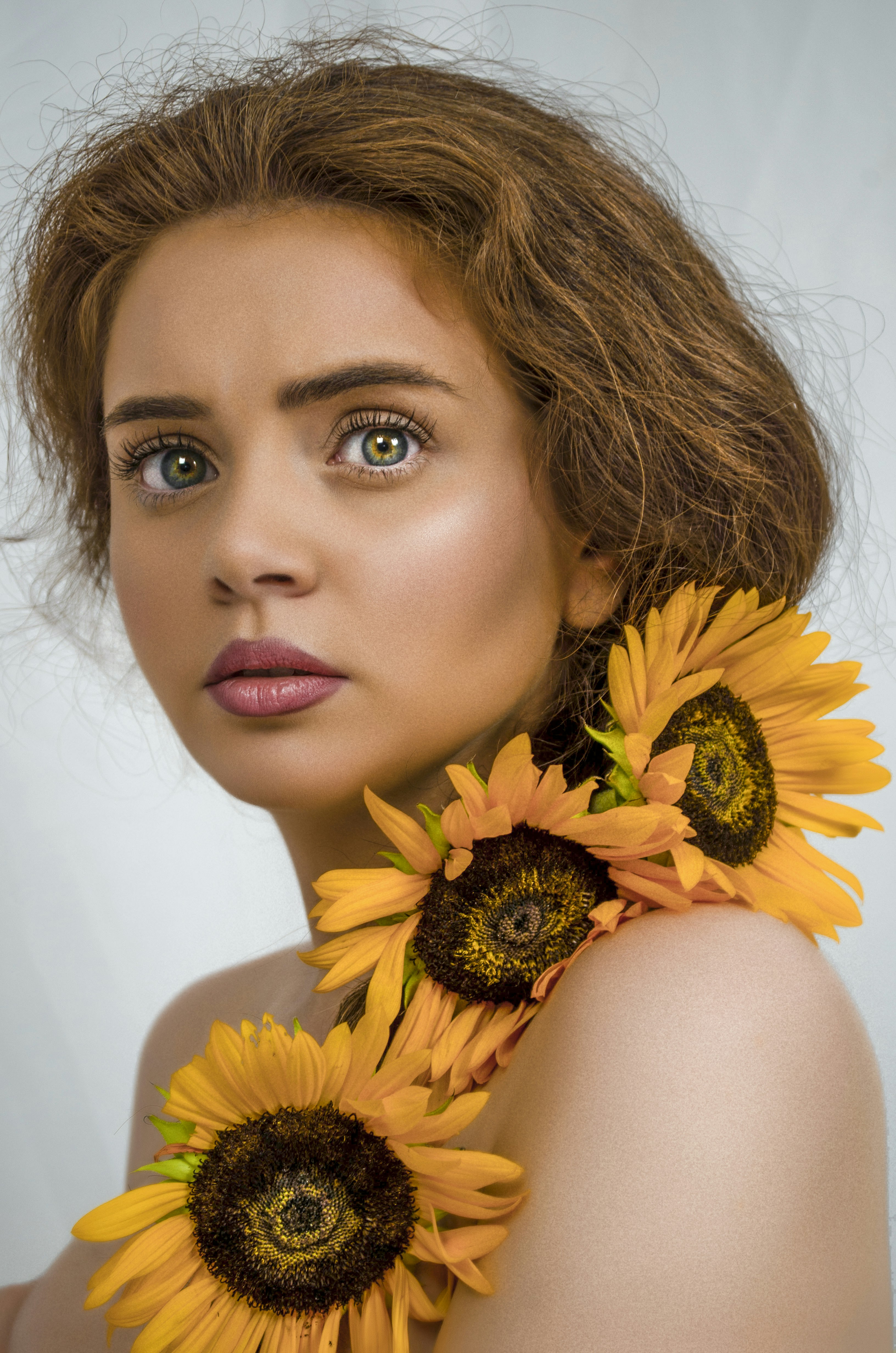 Amber Gaze Among Sunflowers: Portrait Framed by Golden Blooms