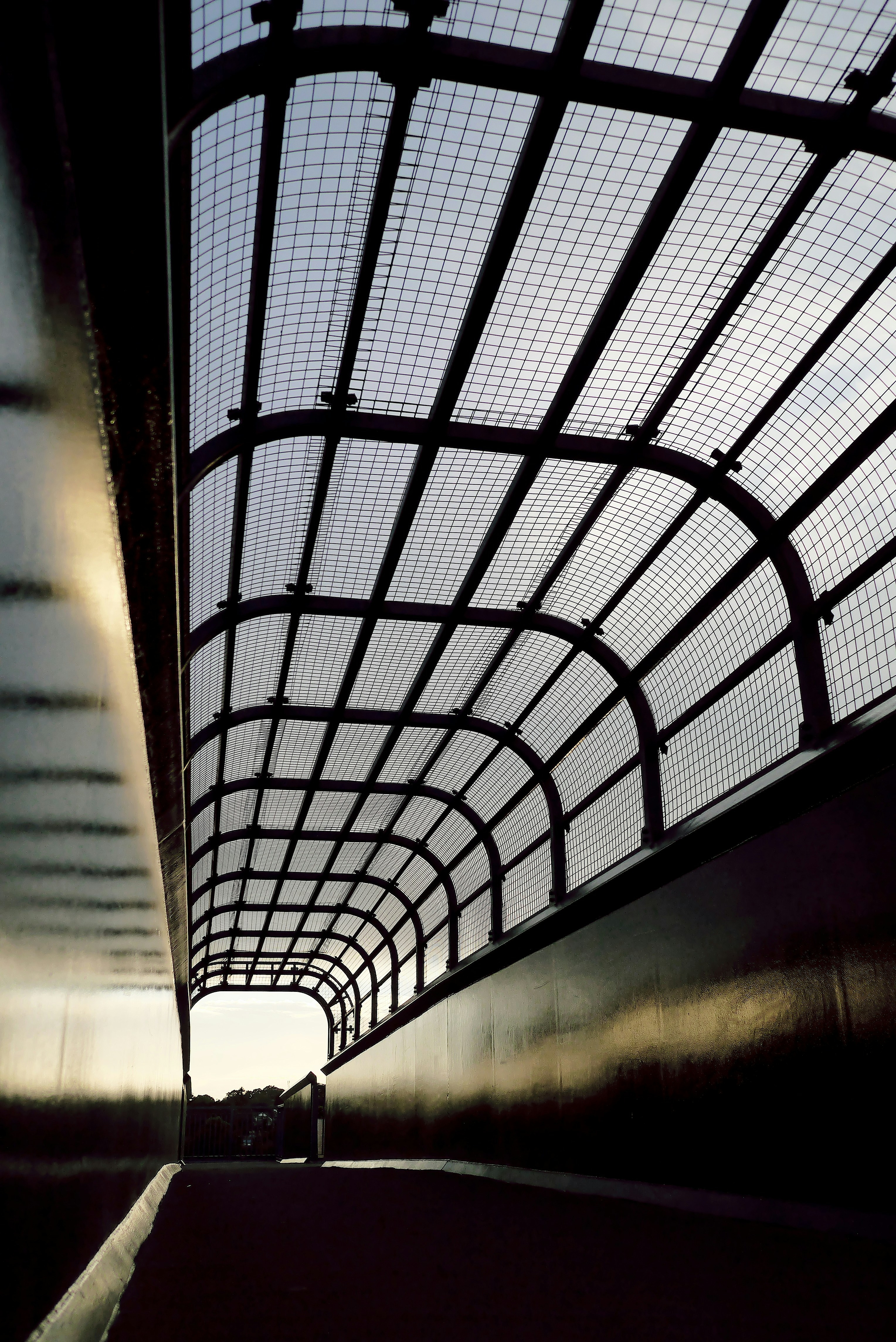 A tunnel glows with the elegance and authenticity of silver above a railway line | a large metal structure