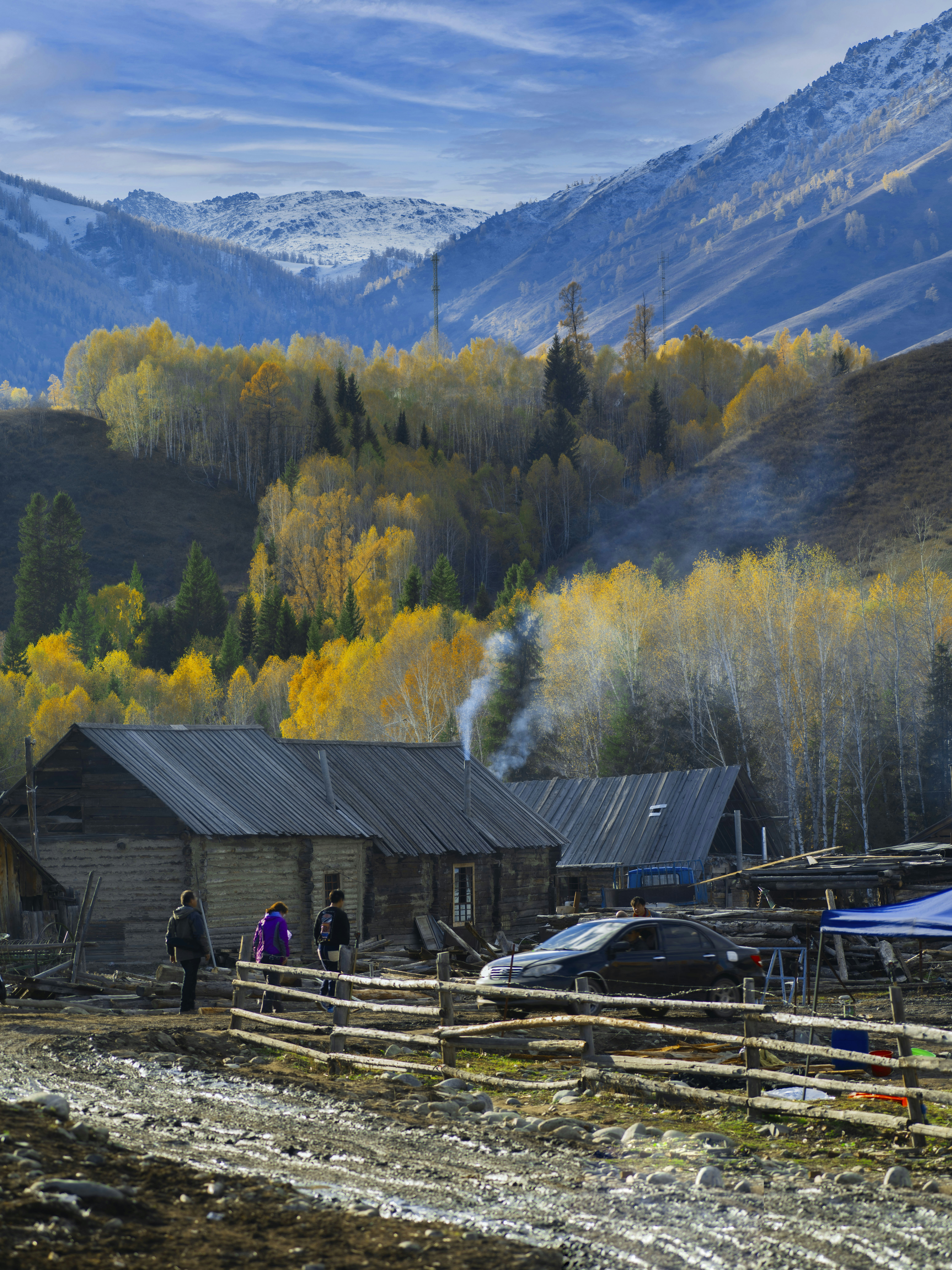 A group of people standing outside a building with trees in the back ...
