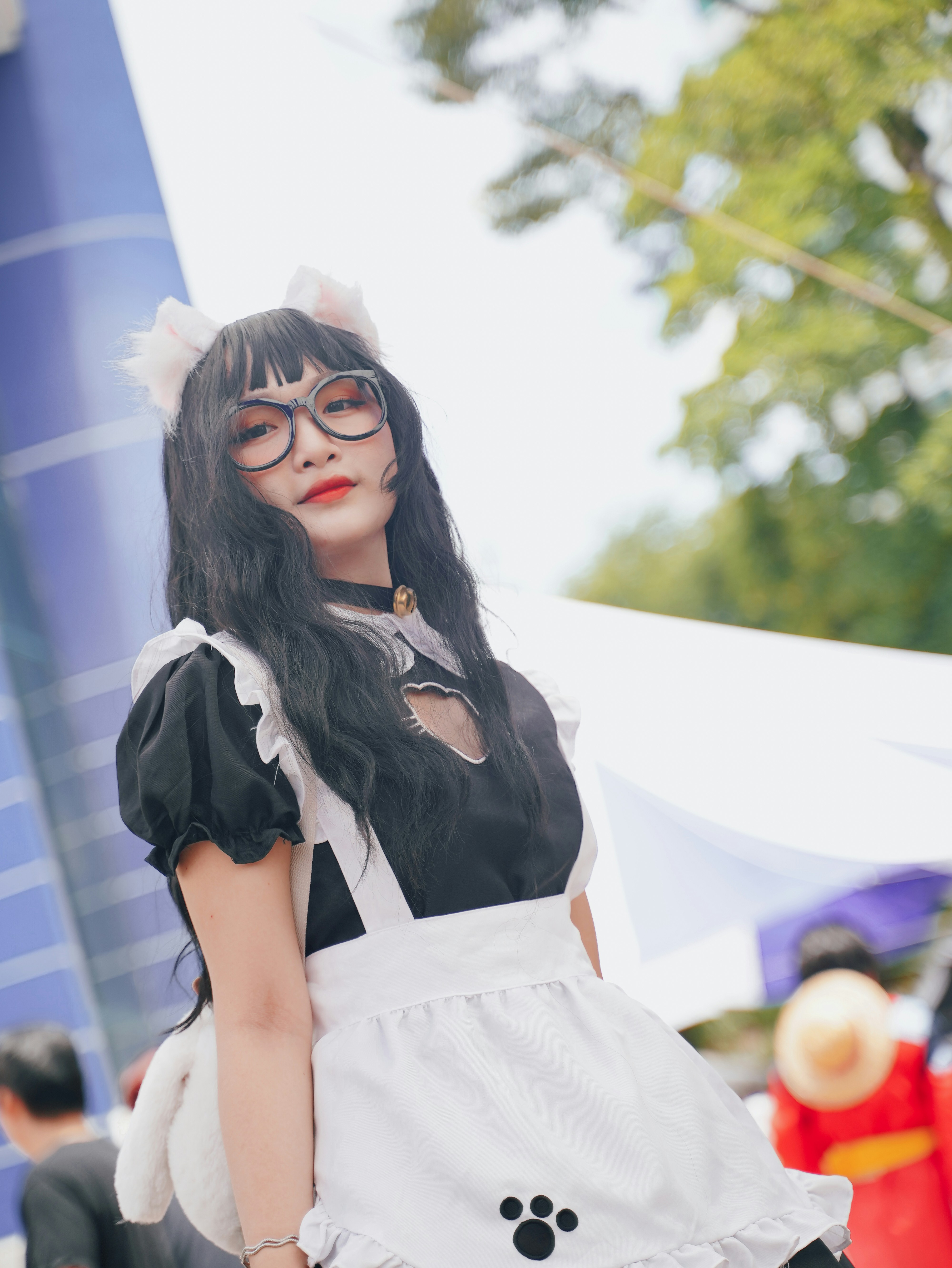 Cat-Eared Maid in Black and White: Cosplay Stance Under Outdoor Canopy
