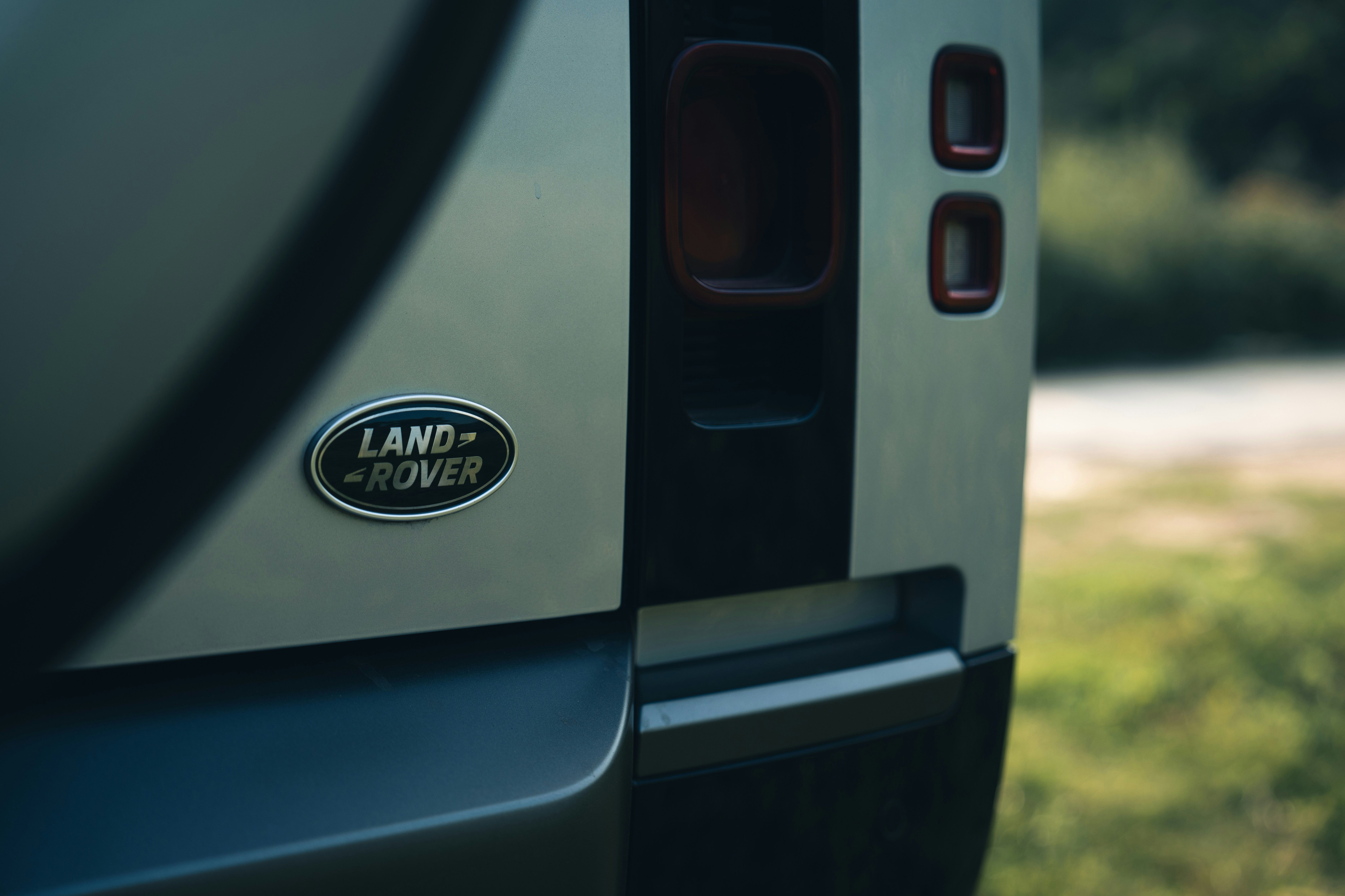 Close-up of a Land Rover badge on the rear of a vehicle, showcasing its iconic design and branding.