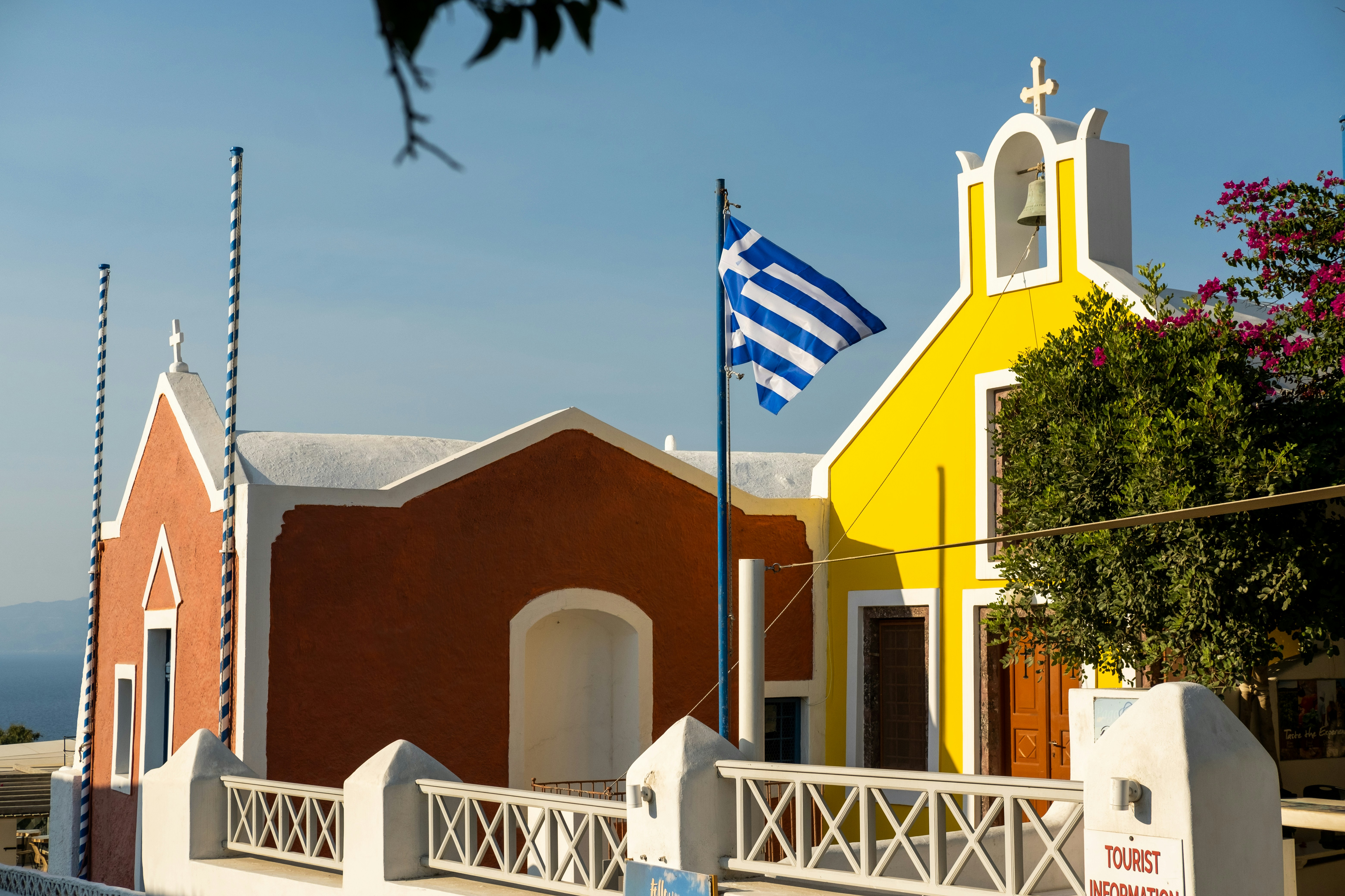 Sunlit Greek Chapel Amid Painted Facades by the Sea