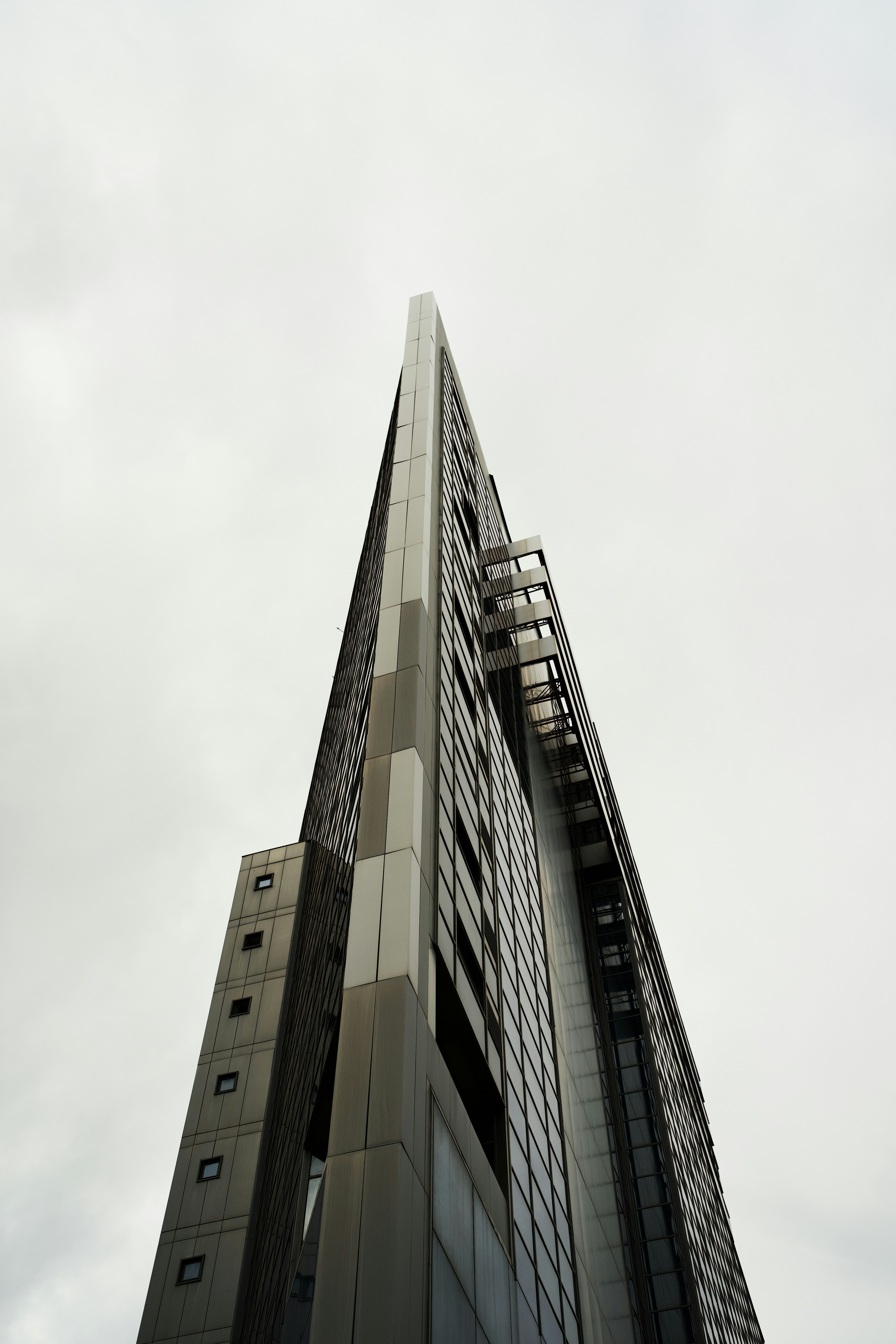 Apex of Glass: Leaning Skyline Piercing the Overcast