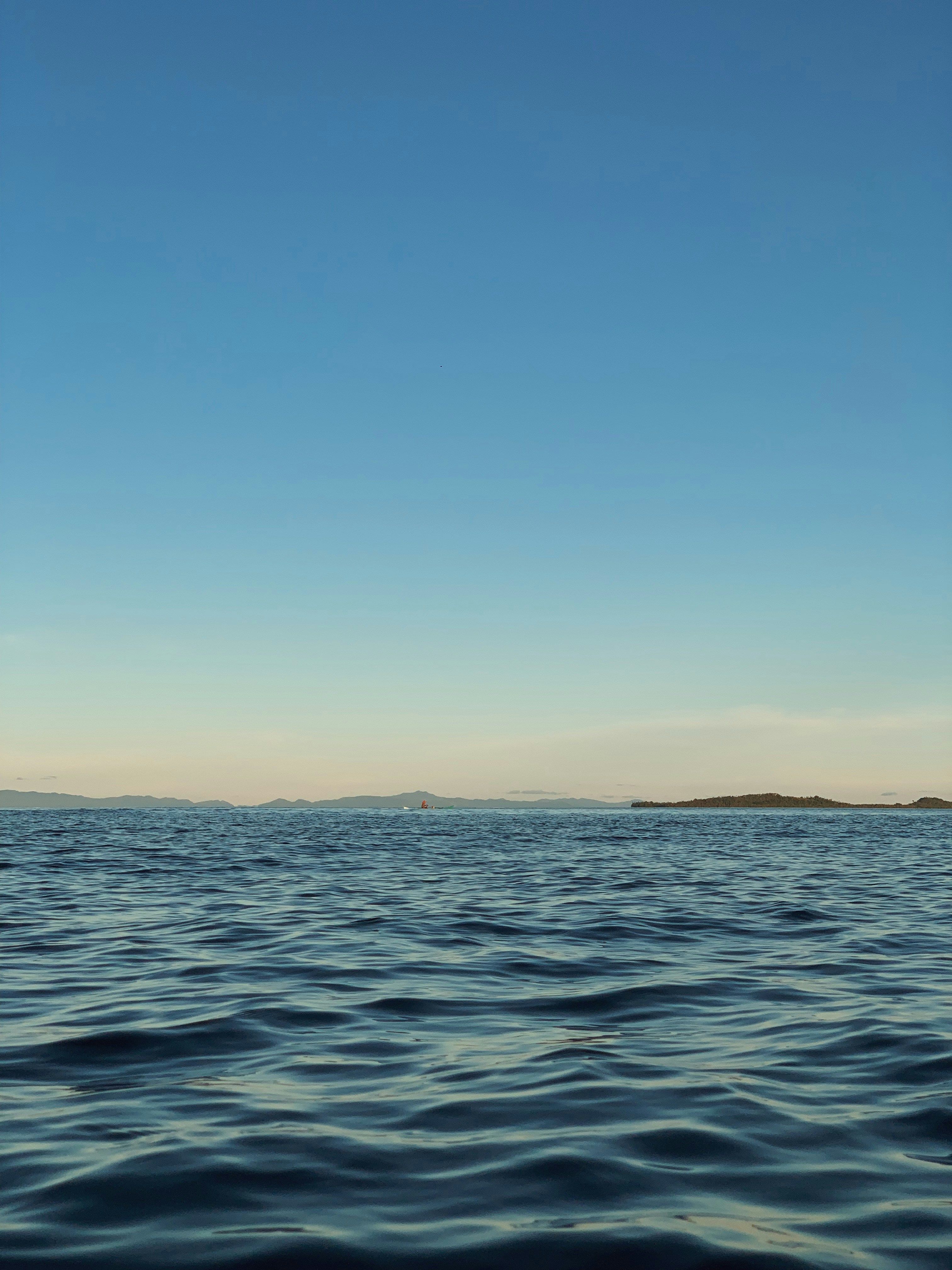 A body of water with land in the distance photo – Free Nature Image on ...