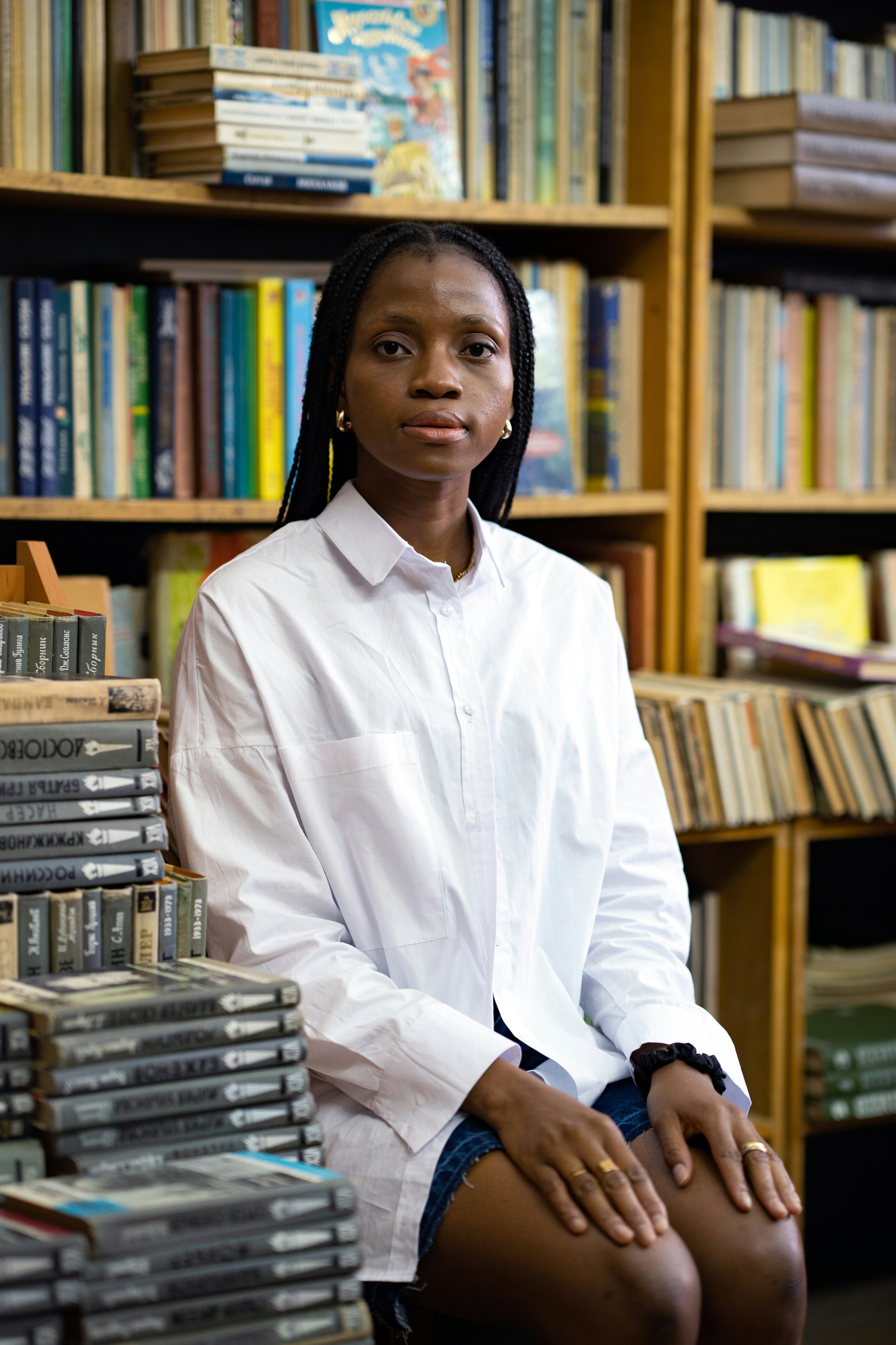 A person sitting in front of a bookshelf photo – Free Portrait Image on ...