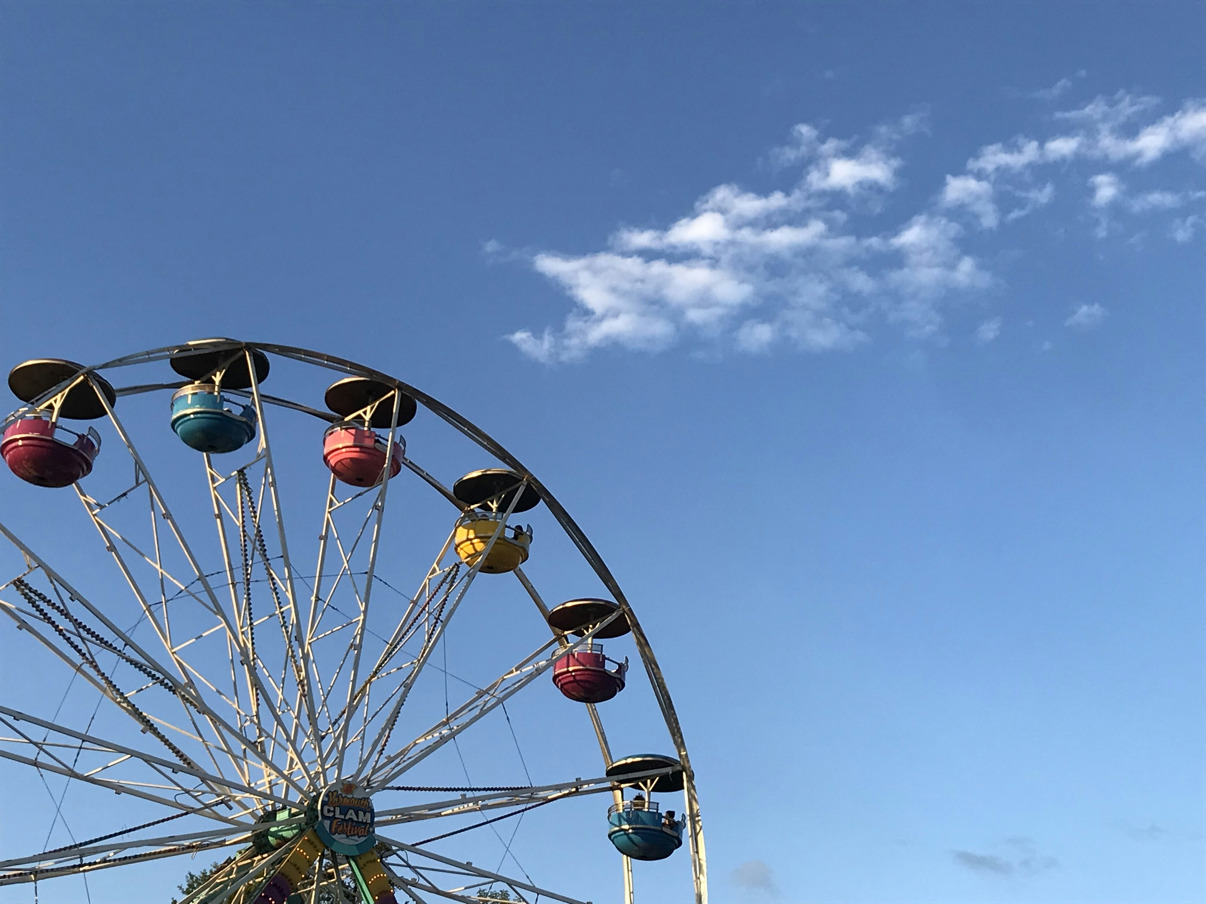 a ferris wheel with blue sky and clouds
