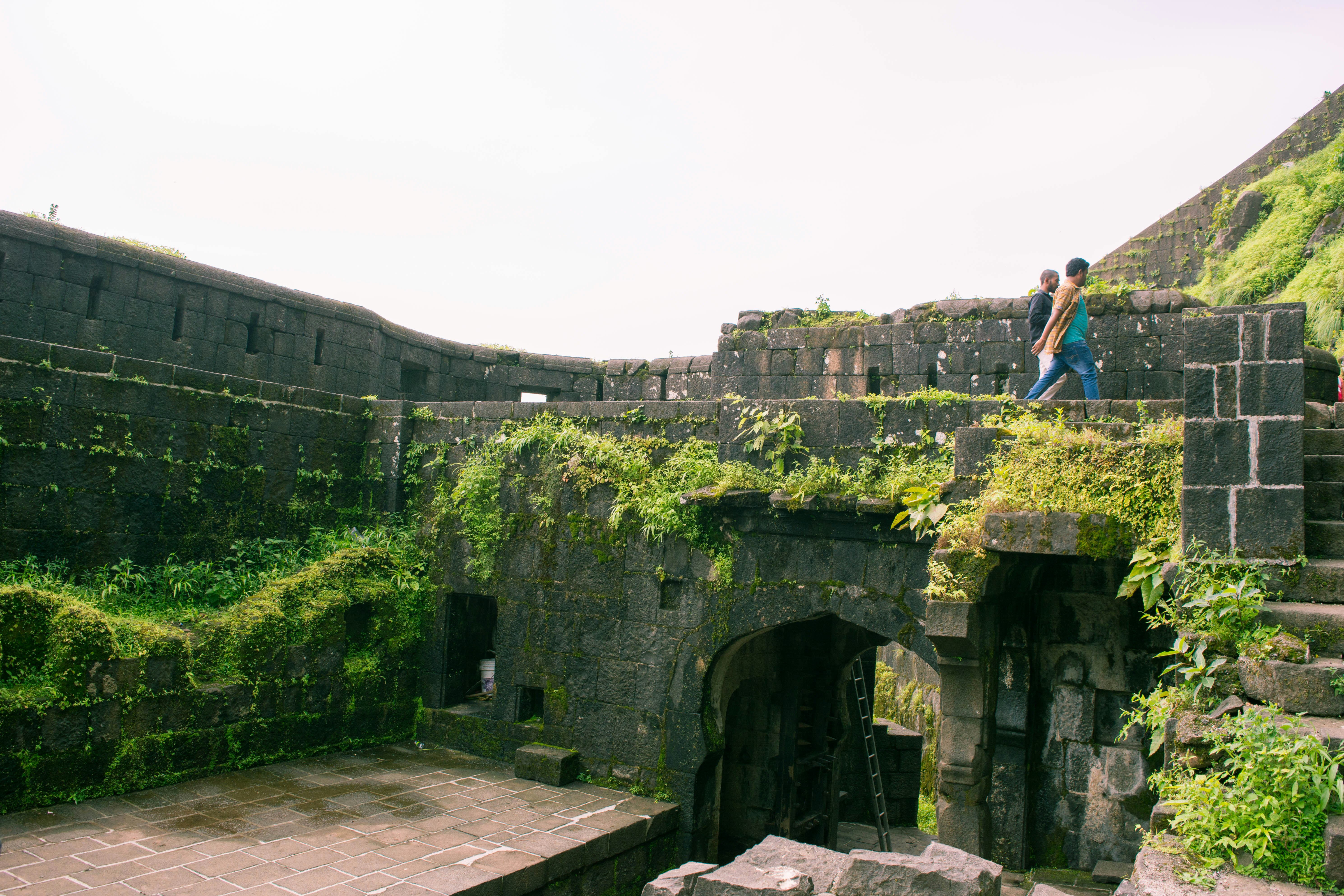 Hikers Traverse a Moss-Covered Coastal Fortress Rampart
