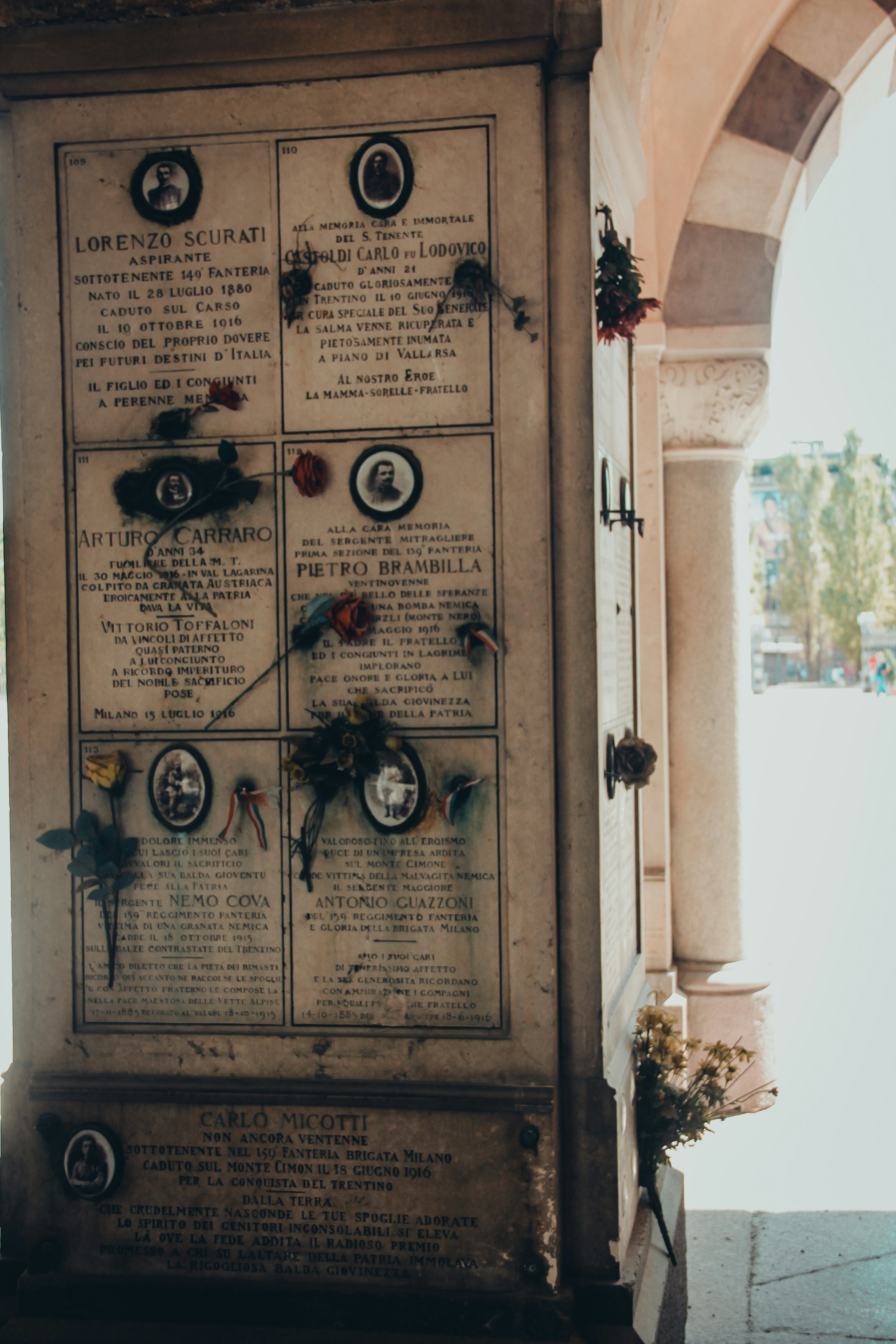 Whispered Names in Stone: A Memorial Panel Framed by a Sunlit Arch