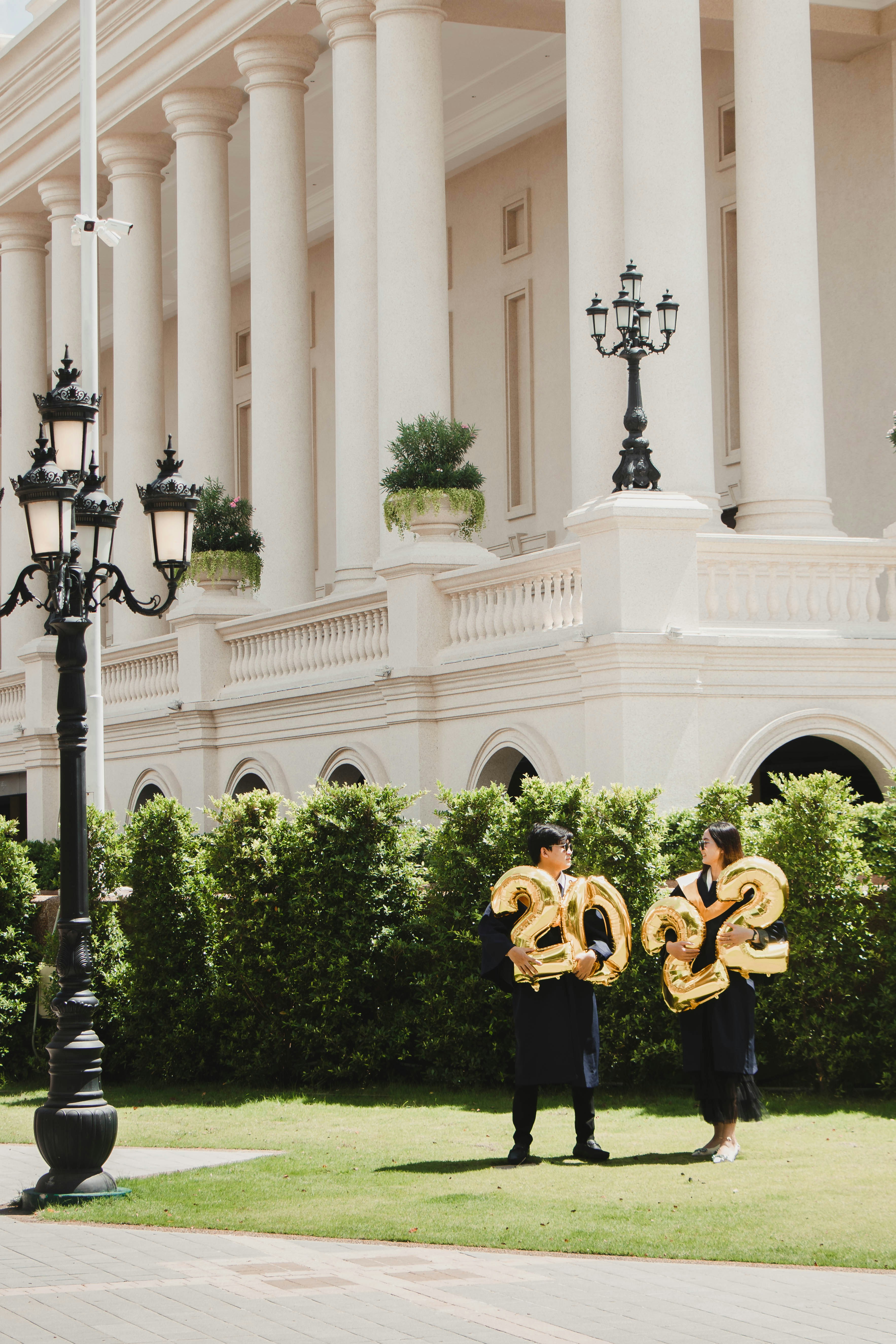 A couple of men playing instruments in front of a white building photo ...