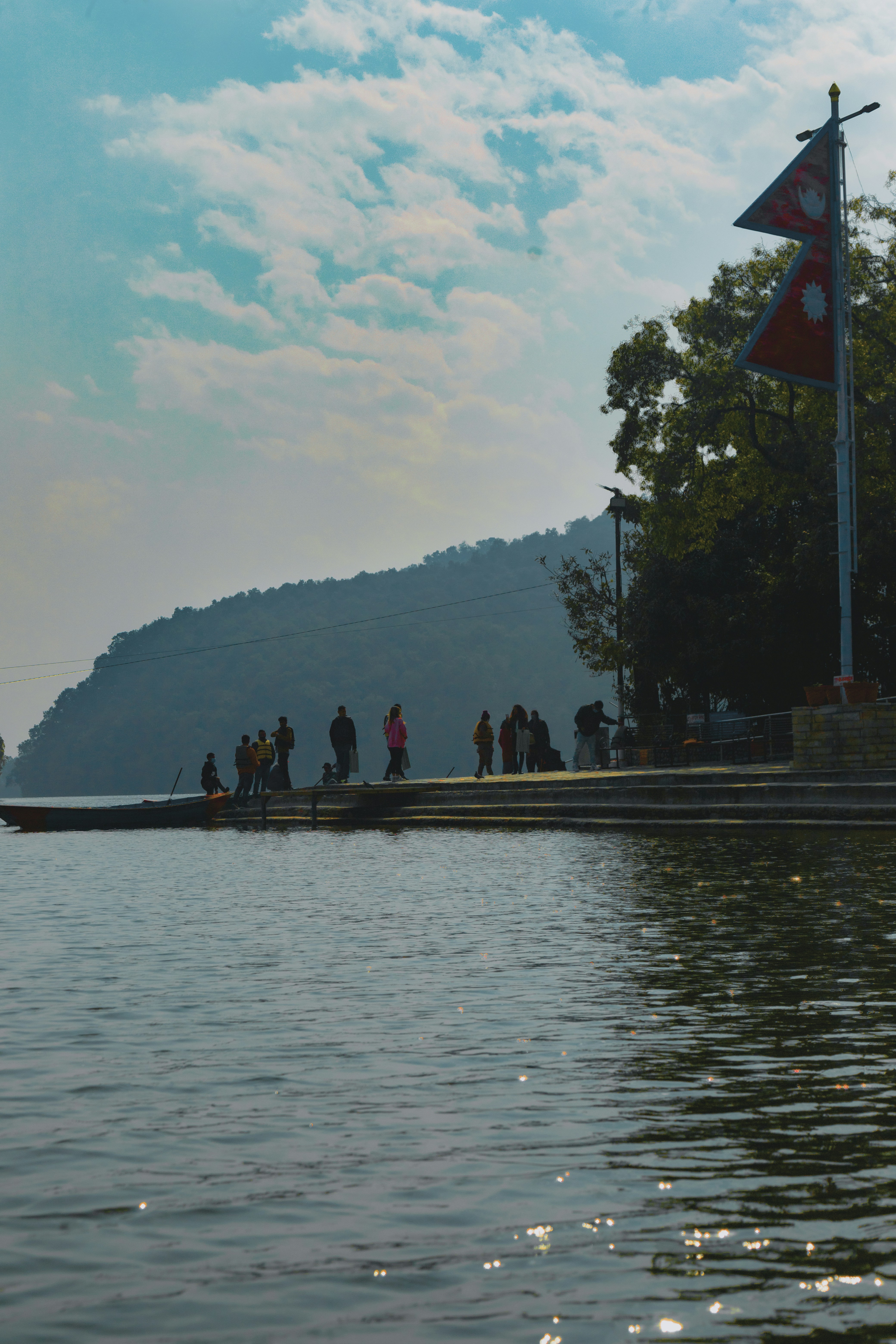A group of people standing on a dock by a body of water photo – Free ...
