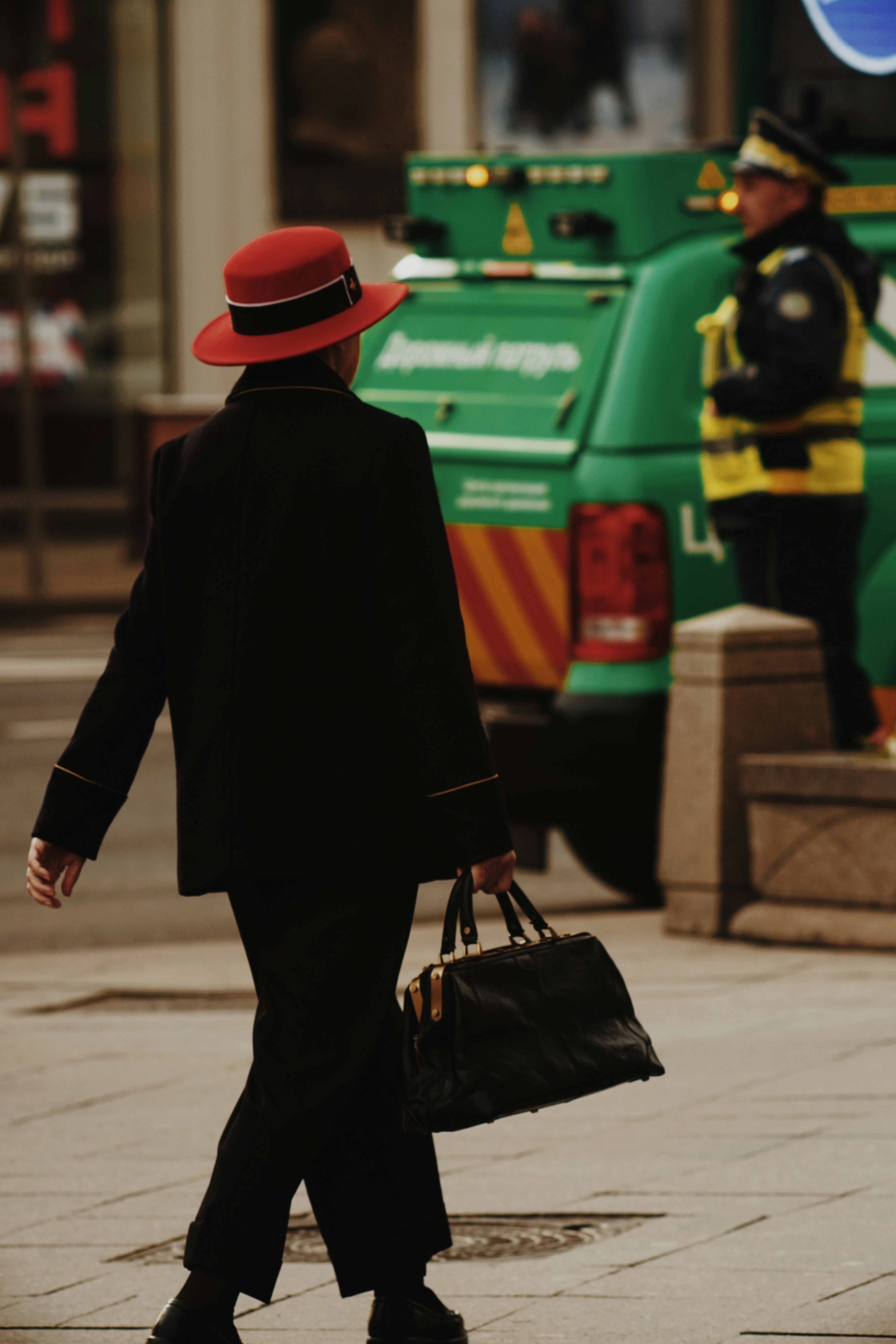 A person in a hat walking down the sidewalk photo – Free Clothing Image ...