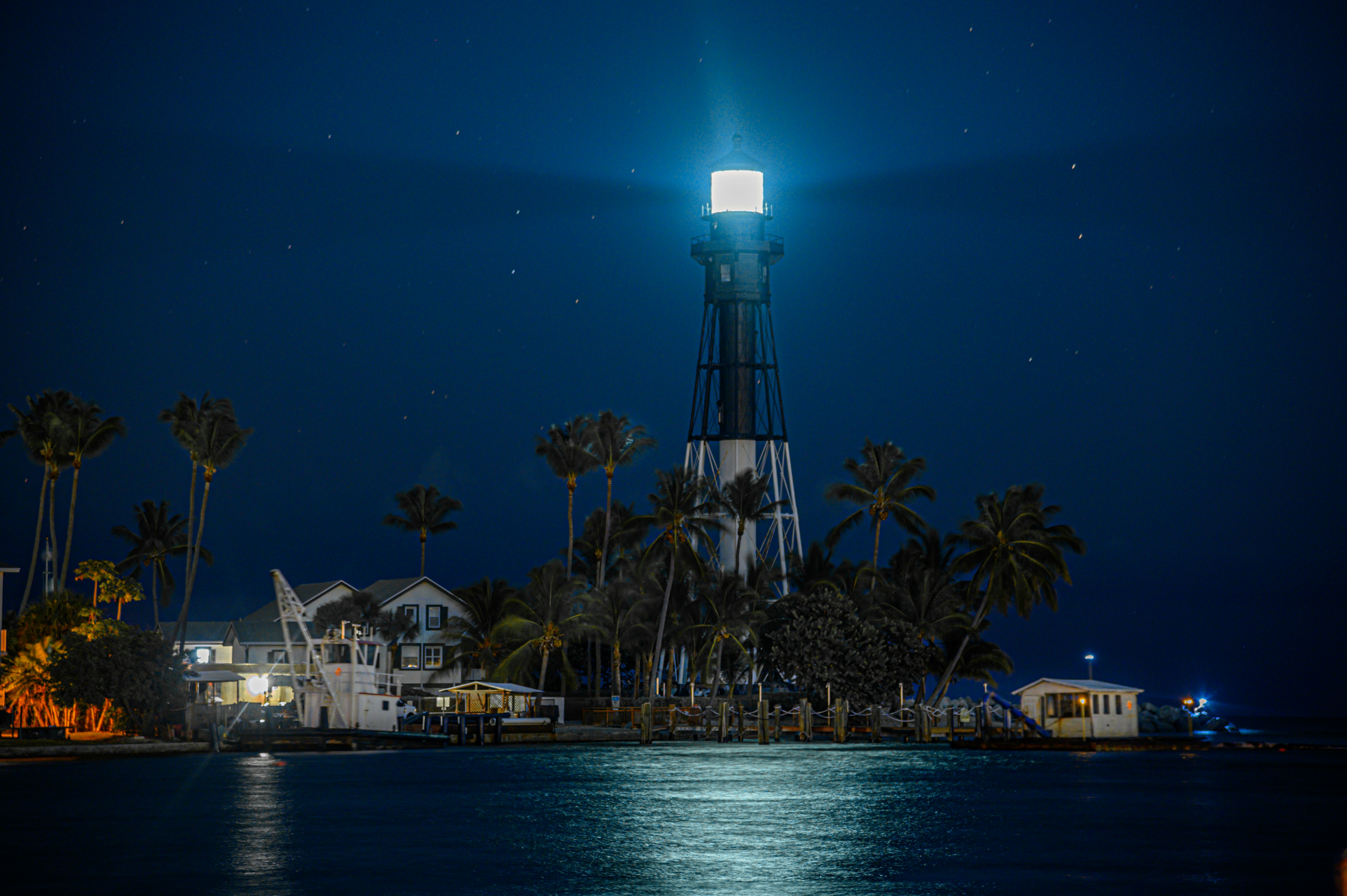 Blue-Hour Beacon: Lighthouse Sentinel Over a Palm-Lined Shore