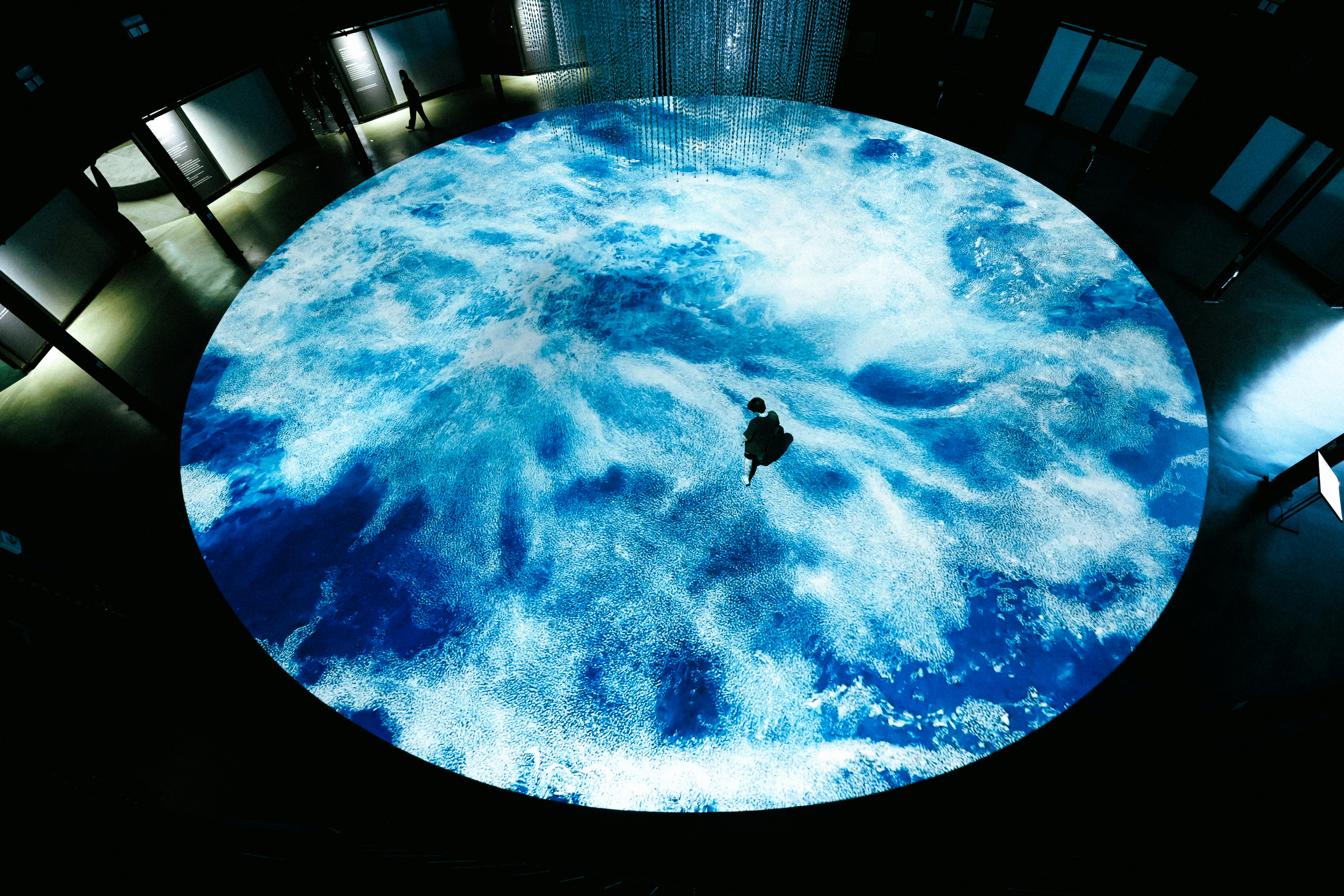 Circle of Waves: A Lone Figure at the Center of the Ocean Floor Projection