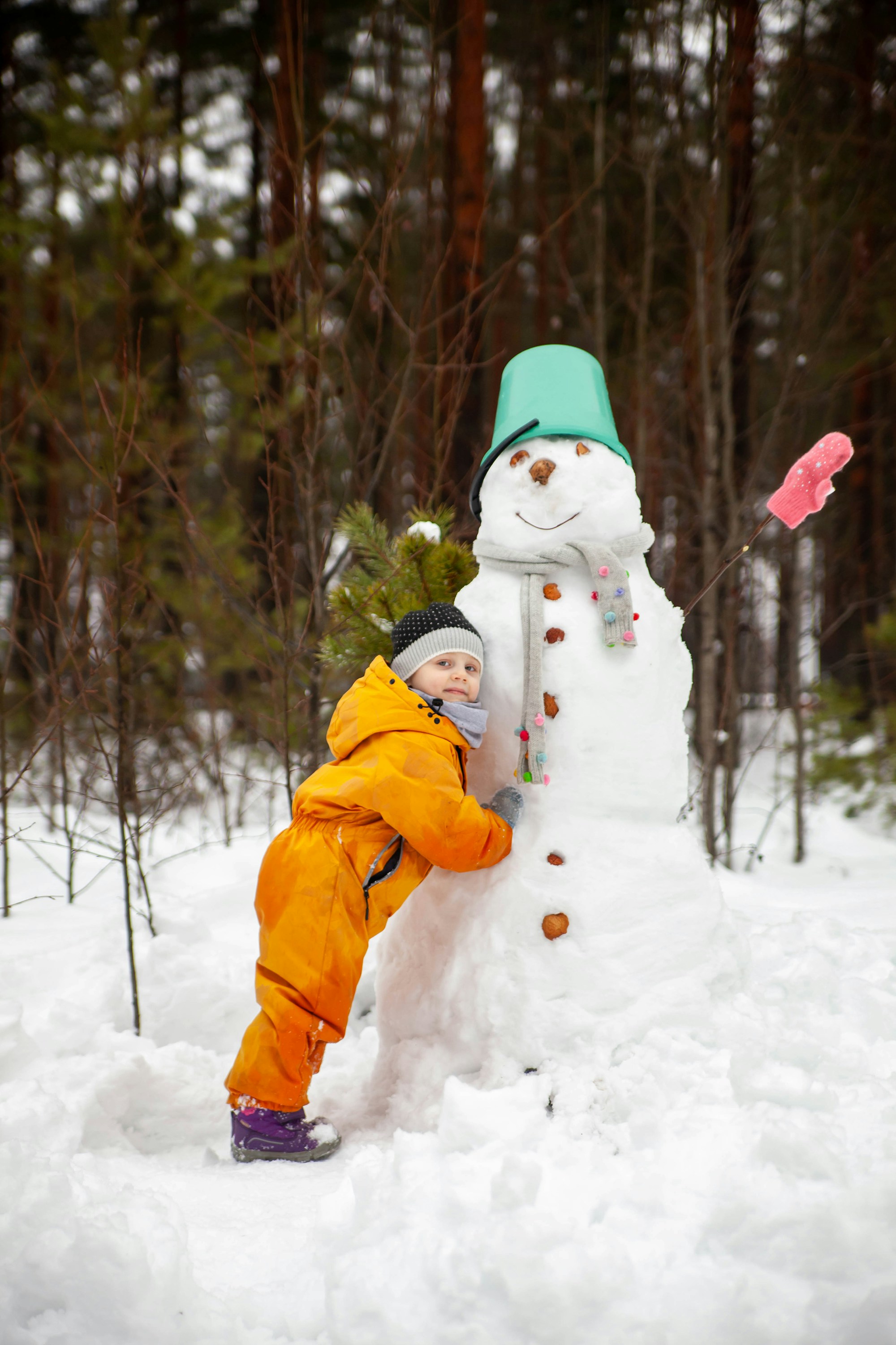 A child standing next to a snowman photo – Free Human Image on Unsplash