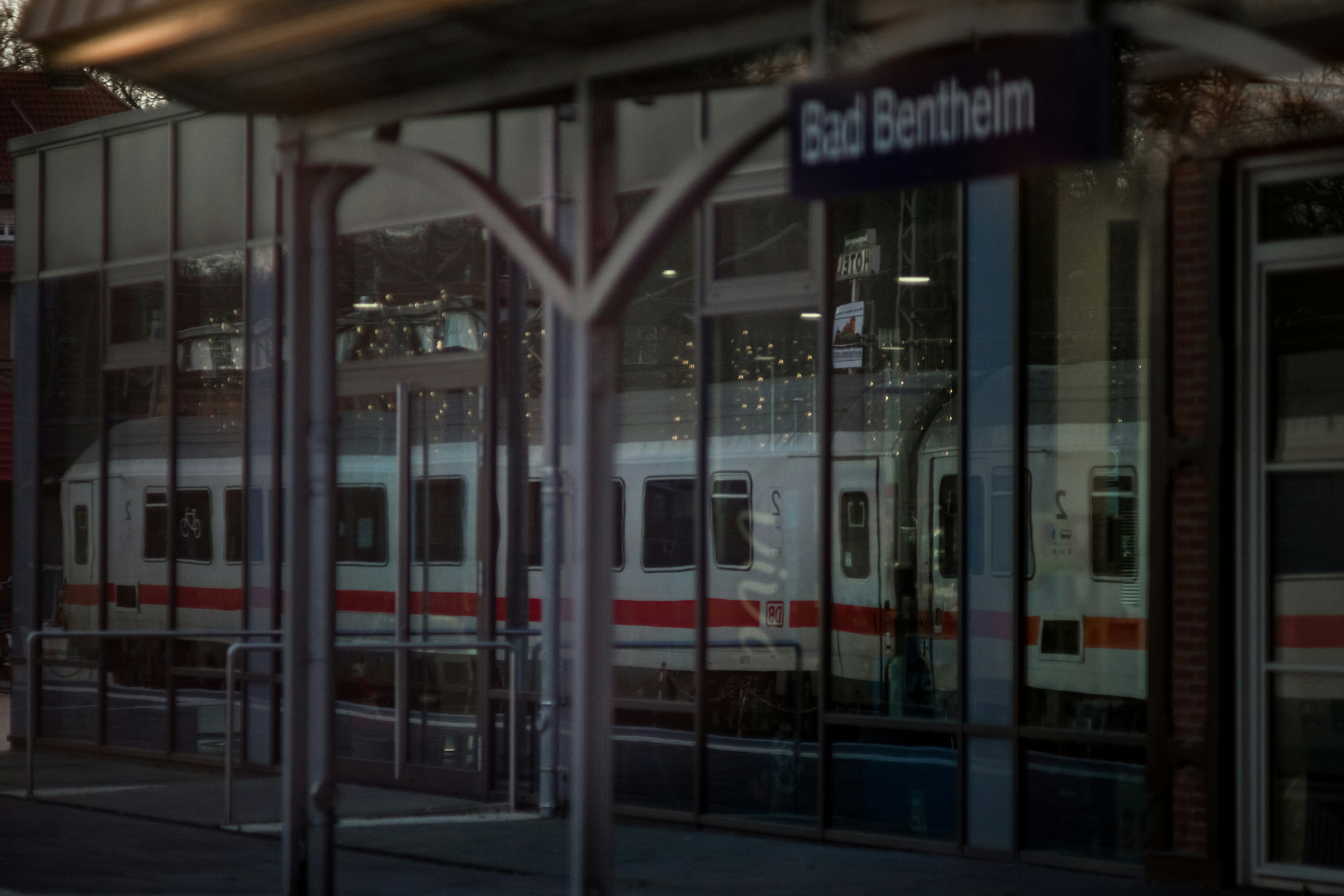 Train reflections distorted in the glass windows of a station.