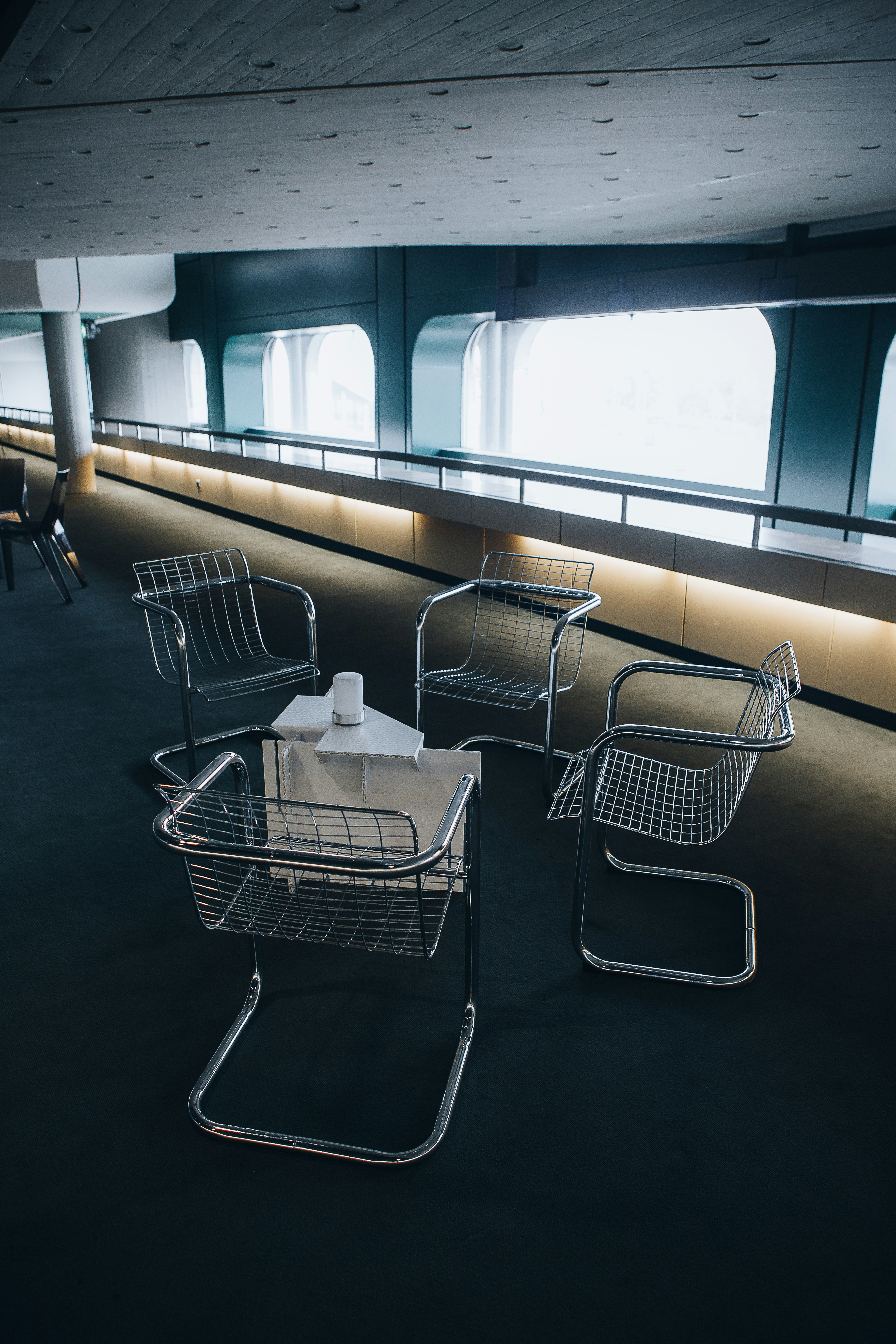 Minimal Lounge in Neon Glow: Metal Cart Chairs Await Conversation