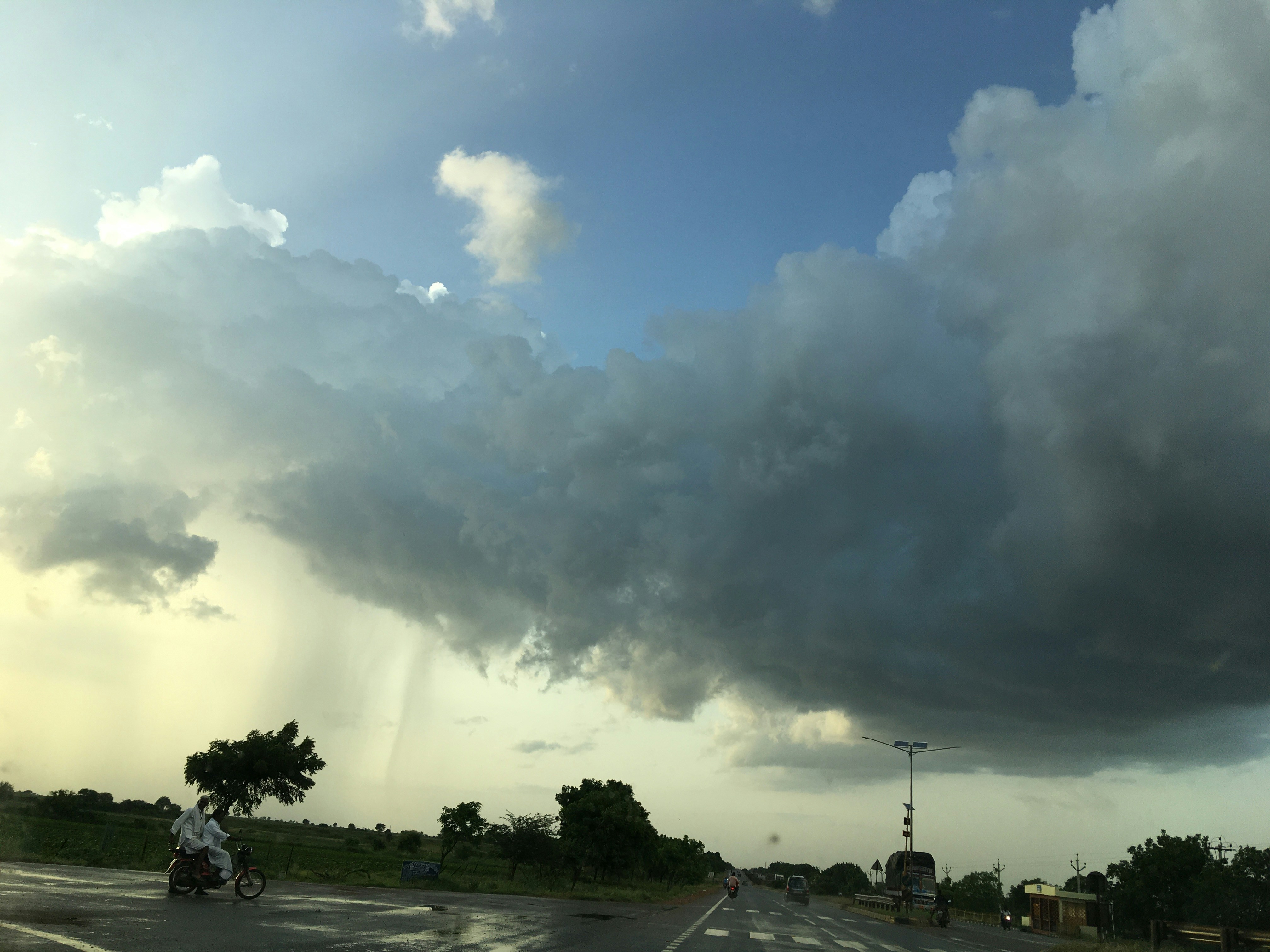 Storm-Split Skies Over a Quiet Highway with a Lone Rider