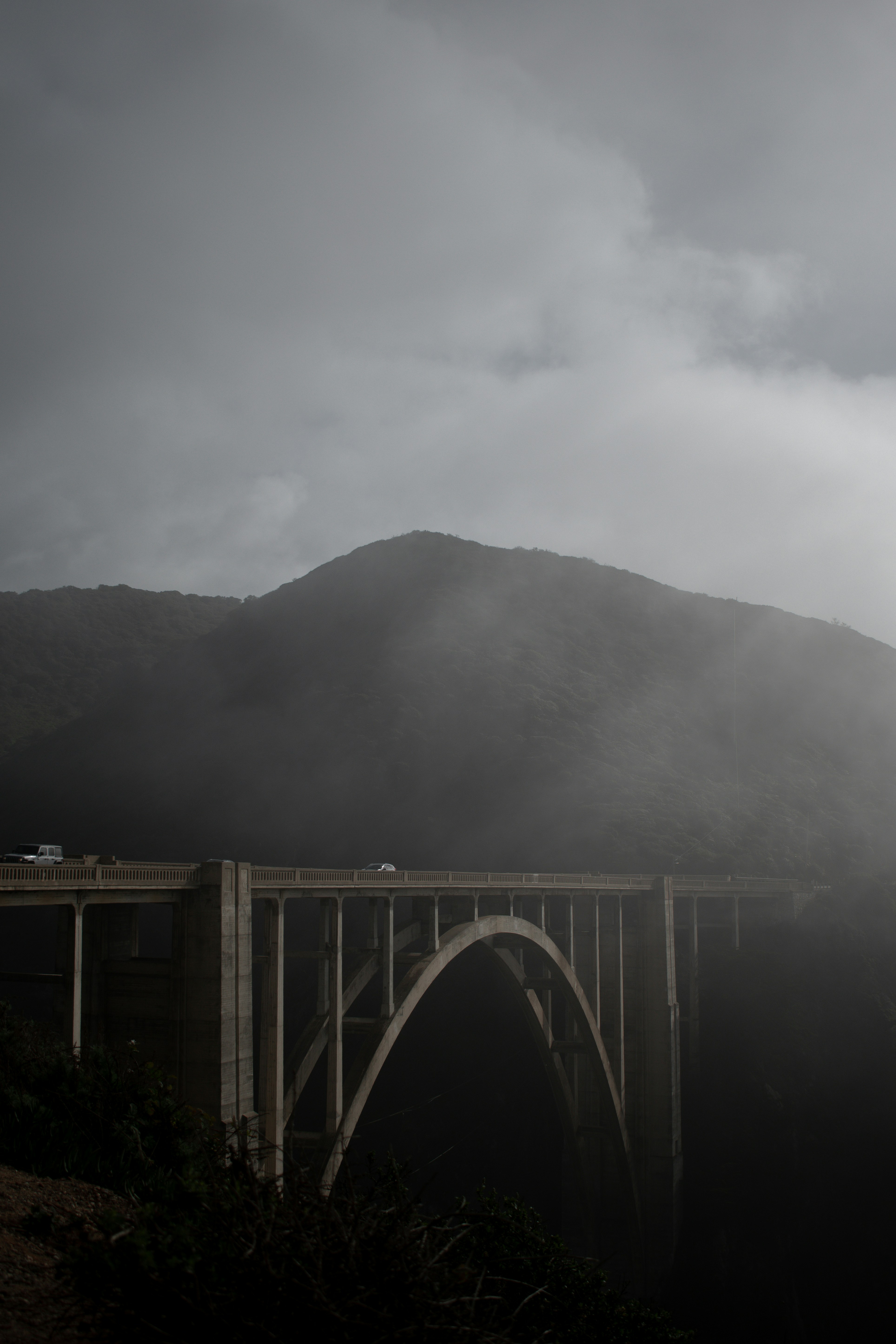 Mist over the Arch: A Mossy Bridge Quietly Carves the Valley