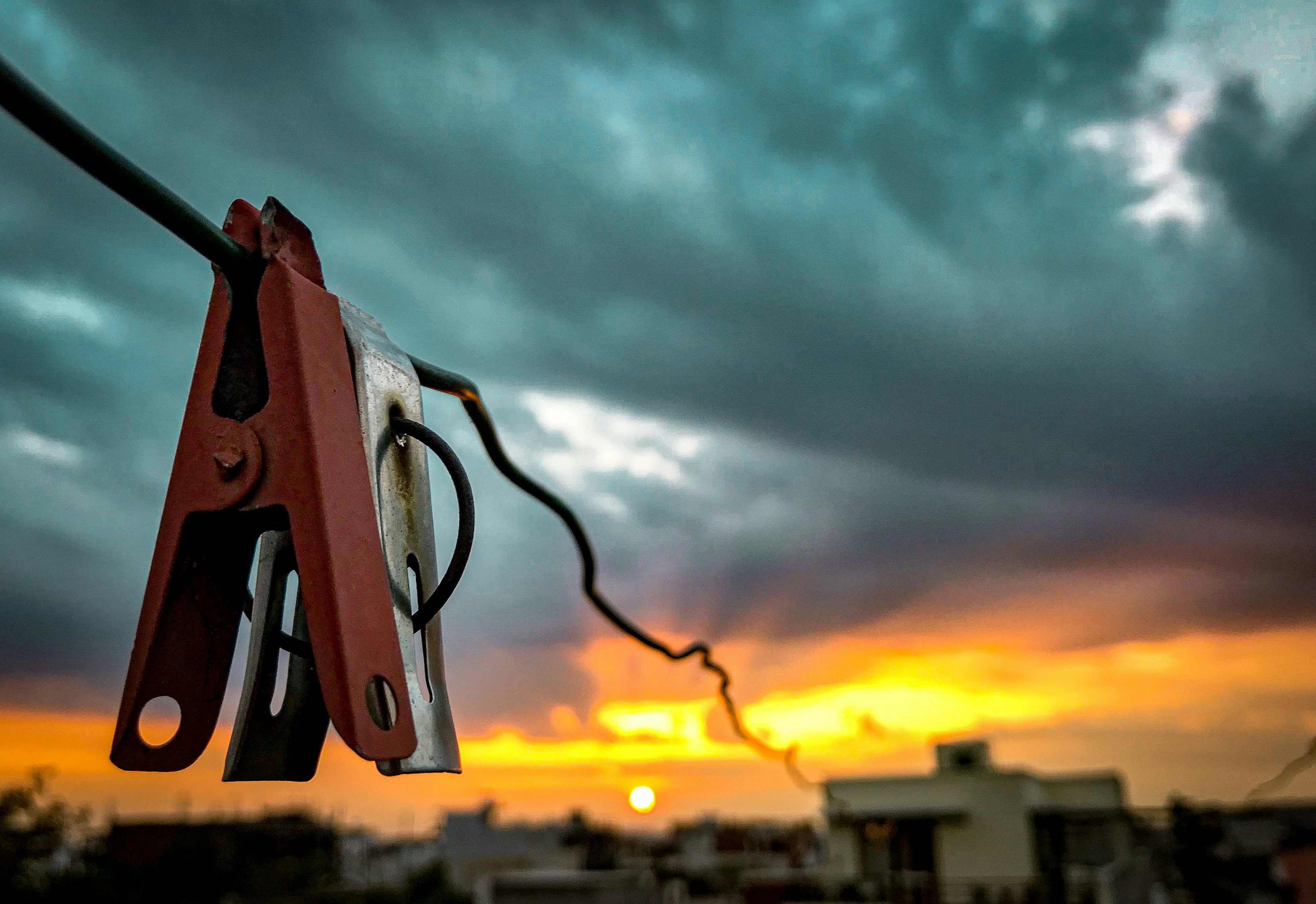 Crimson Clothespin at Dusk Over a Quiet City Skyline