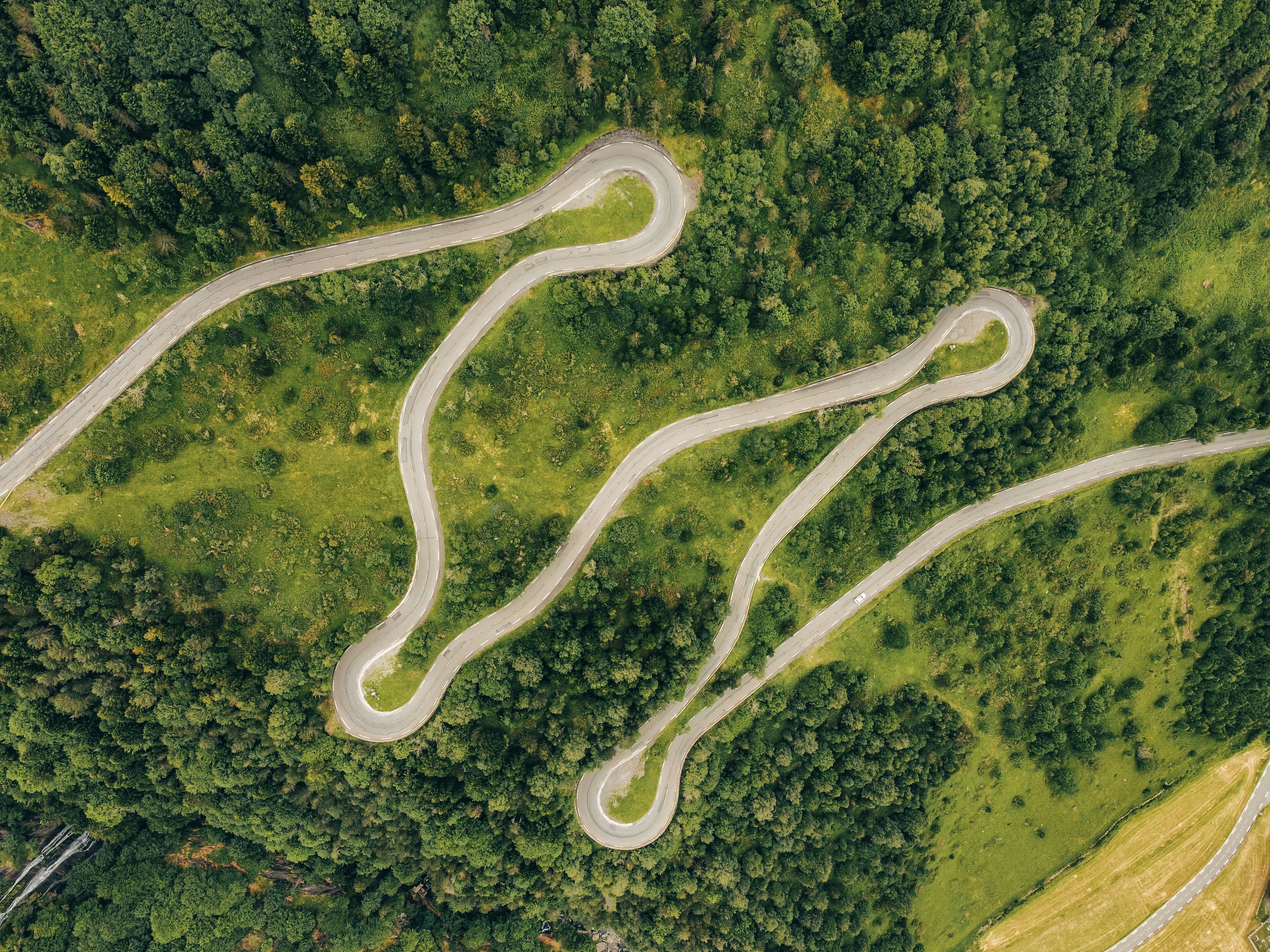 A winding road through a forest photo – Free Mountain road from above ...