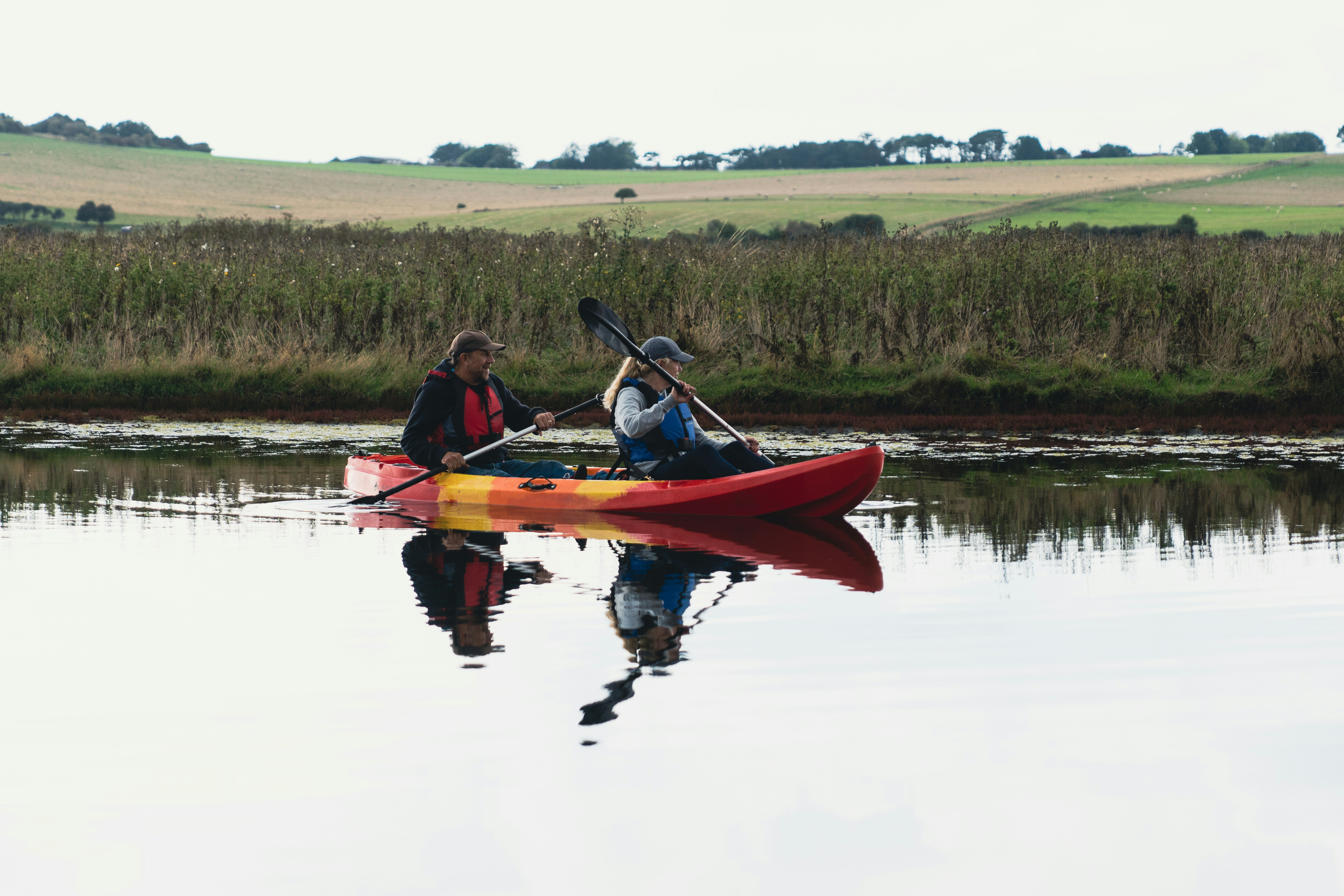 A couple of people in a canoe on a river photo – Free Person Image on ...