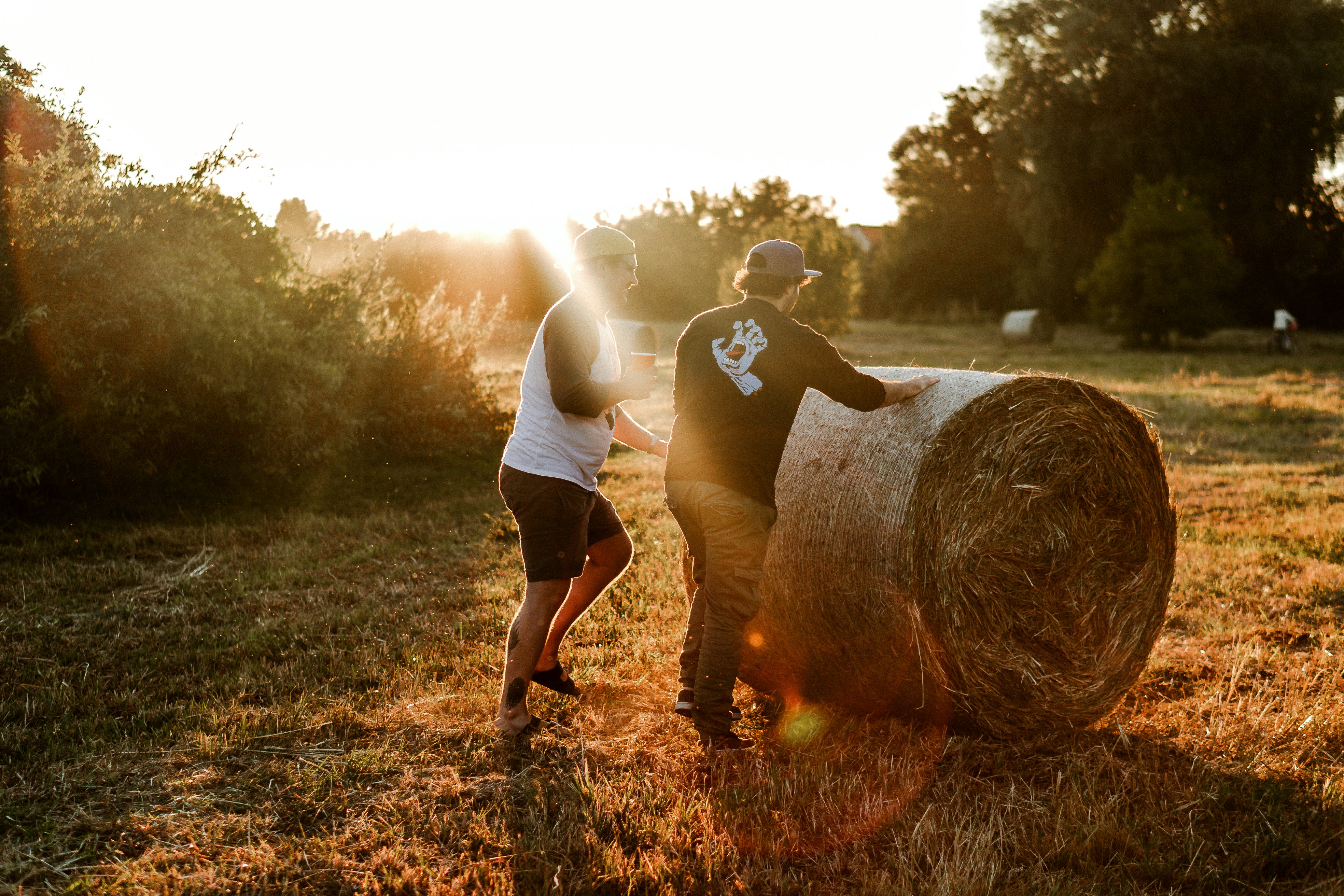 A man and woman standing next to a large round object outside photo ...