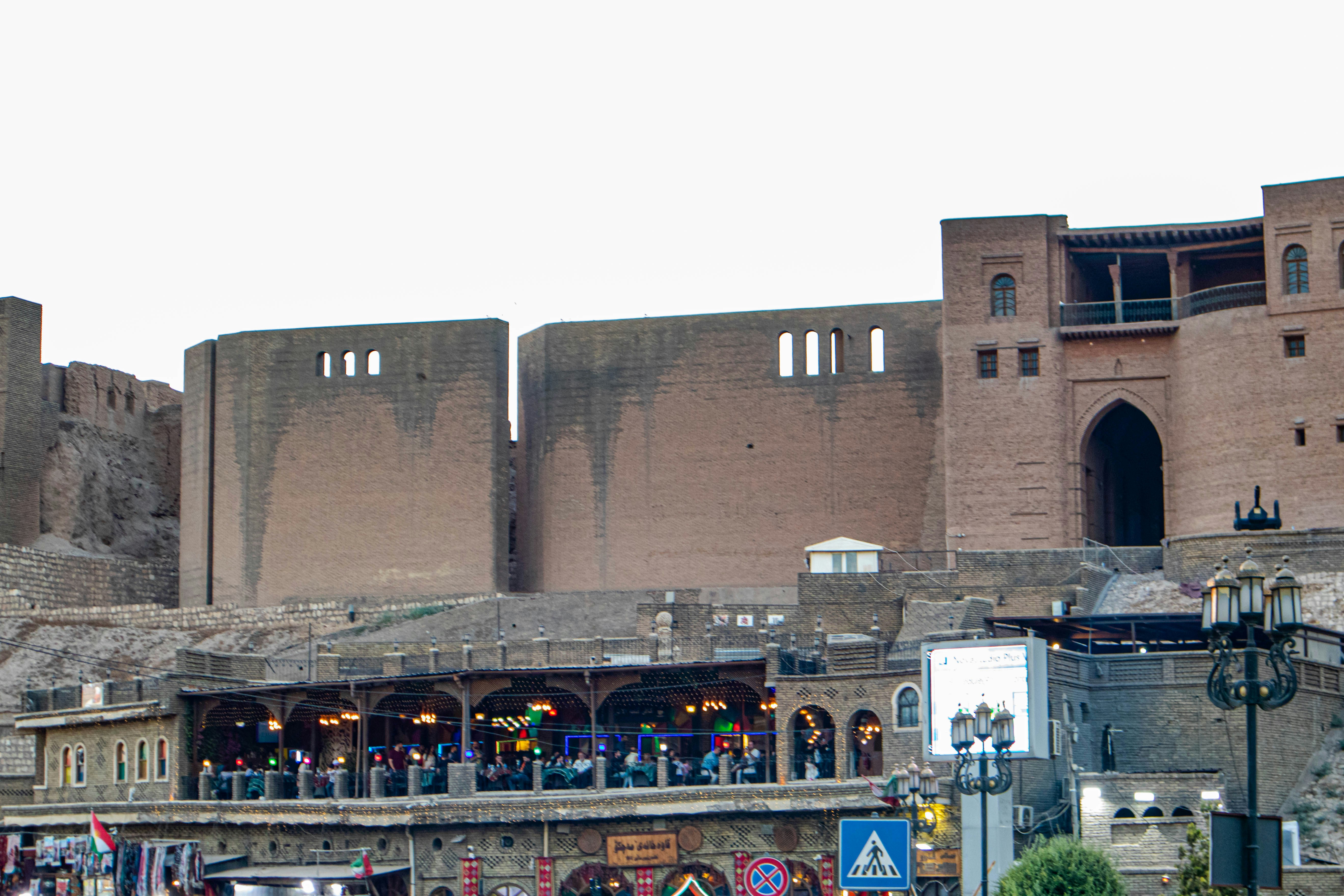 A large brick building with a crowd of people in front of it photo ...